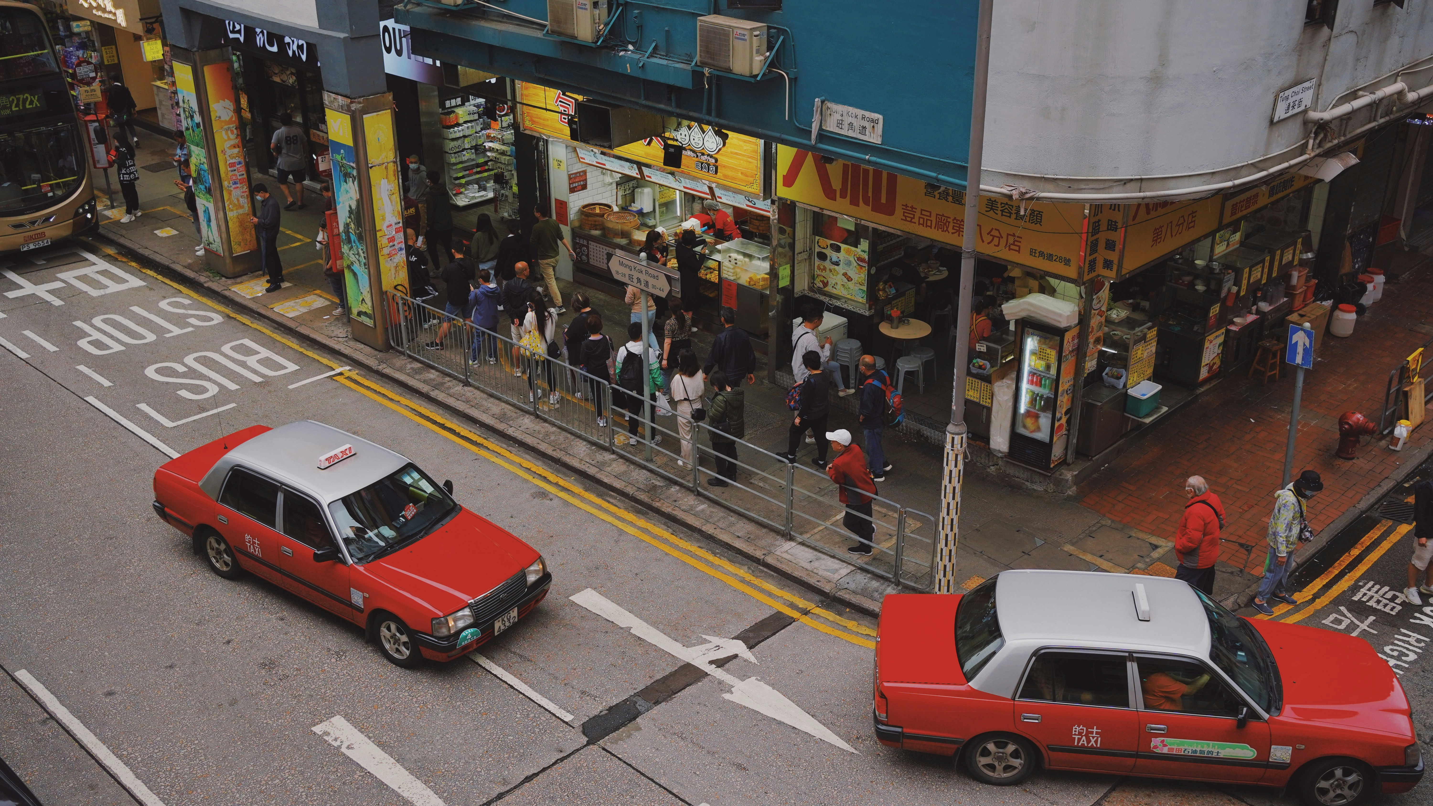 Crossing Pulse: A Red-Taxi Parade Along a Bustling Street