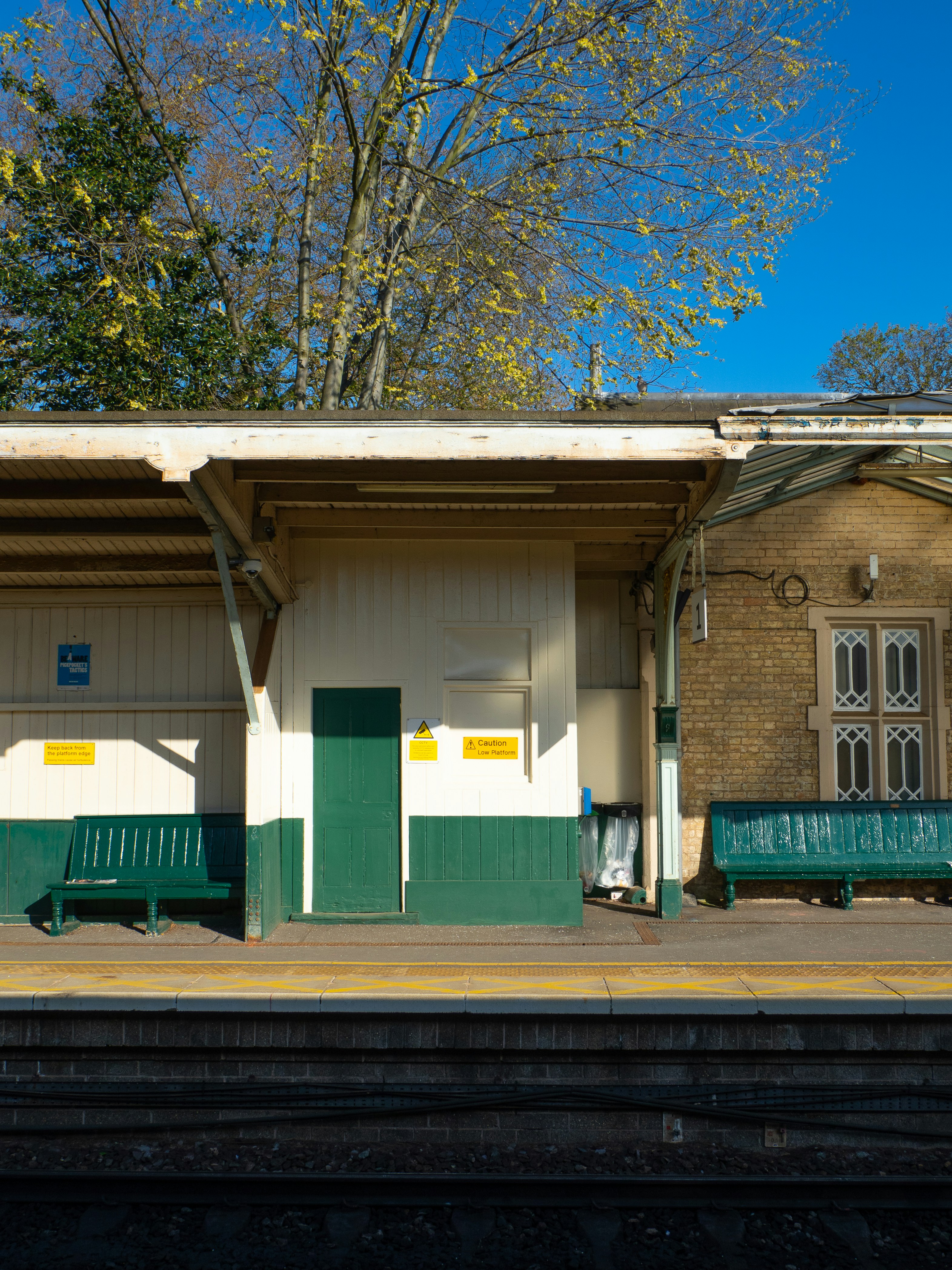 Green Door at a Quiet Platform Under a Clear Blue Sky