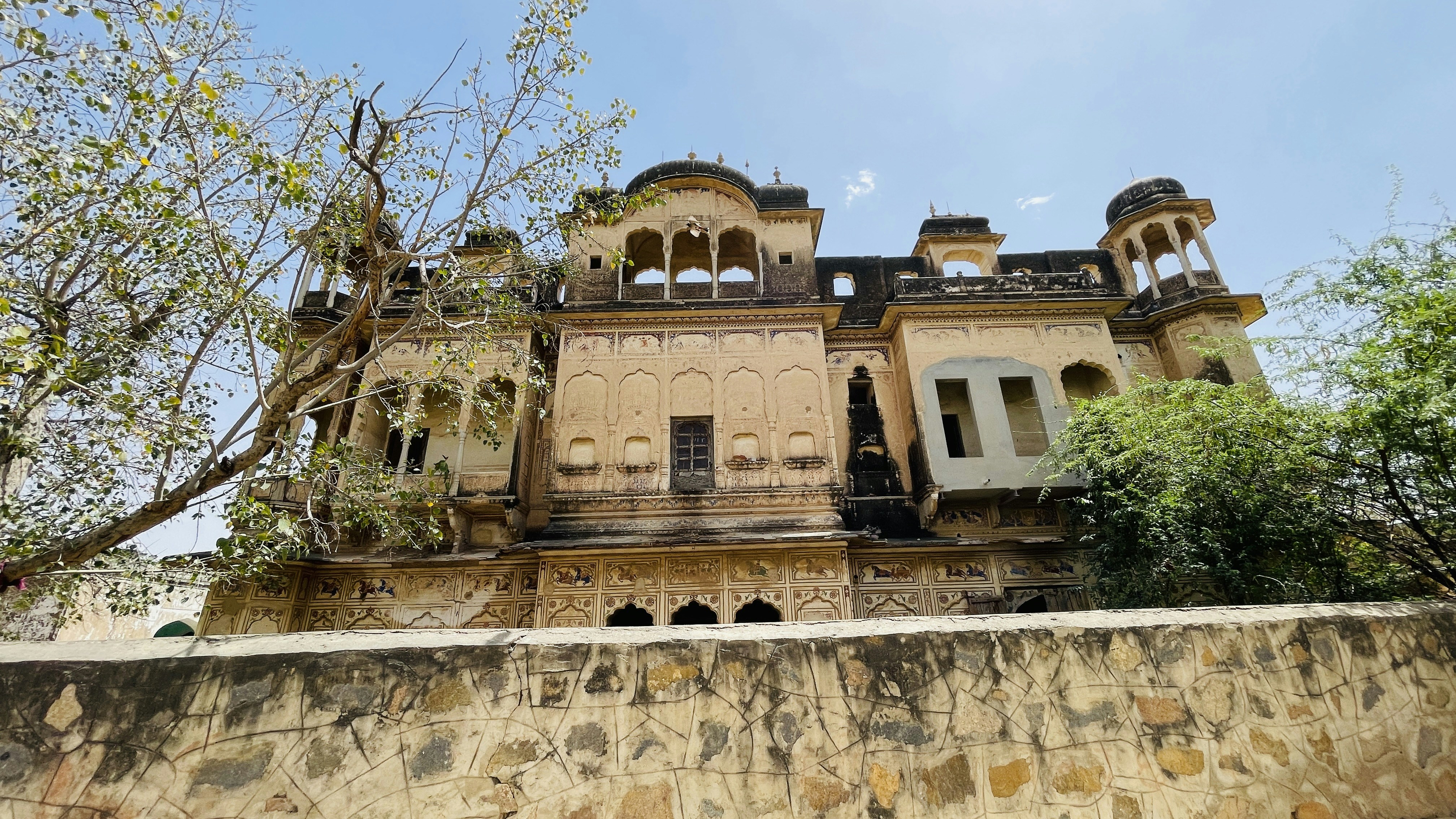Sunlit Haveli Crowned by Arches Above a Weathered Rampart