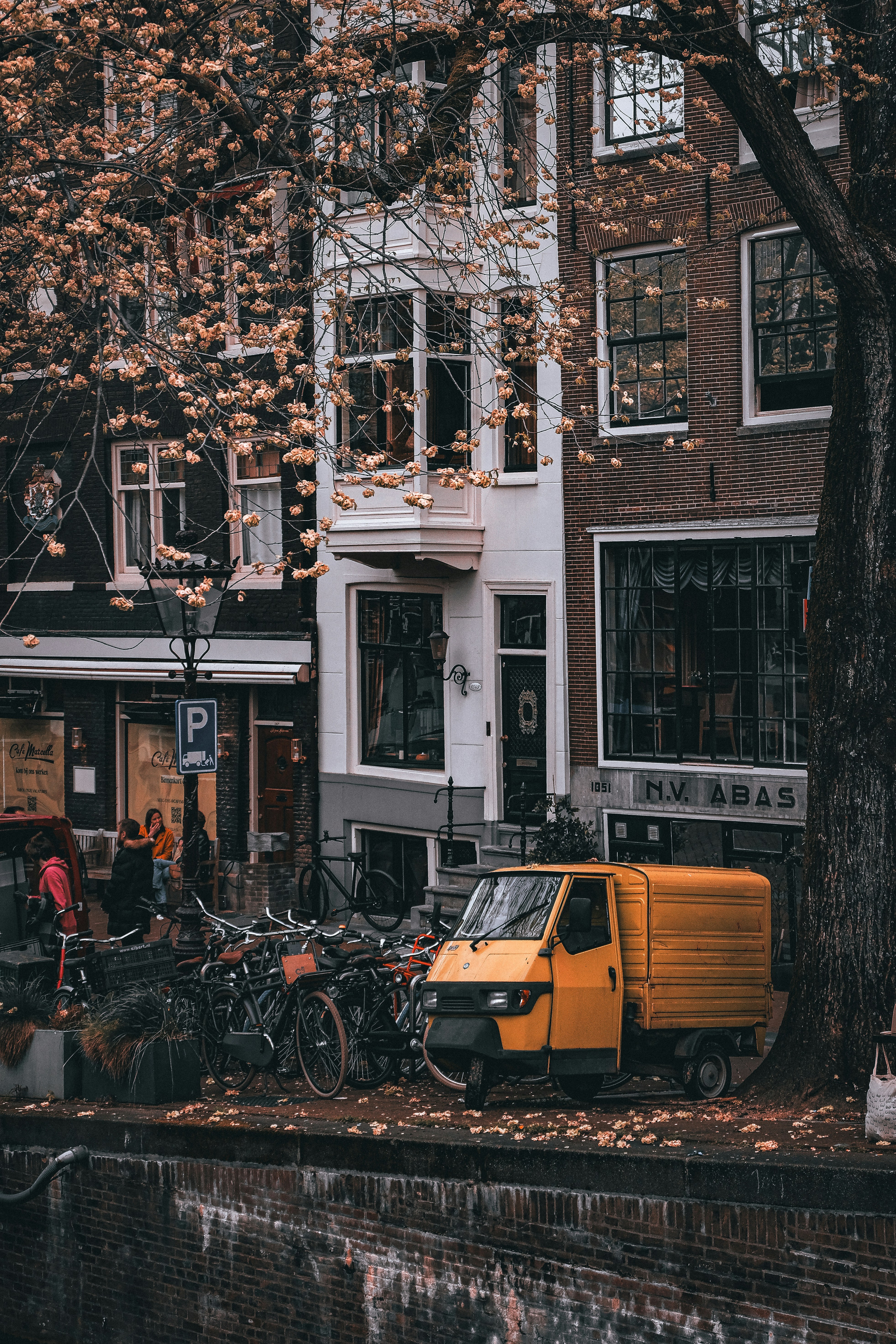 Yellow Van by the Canal: Autumn Street with Bicycles and Brick Facades