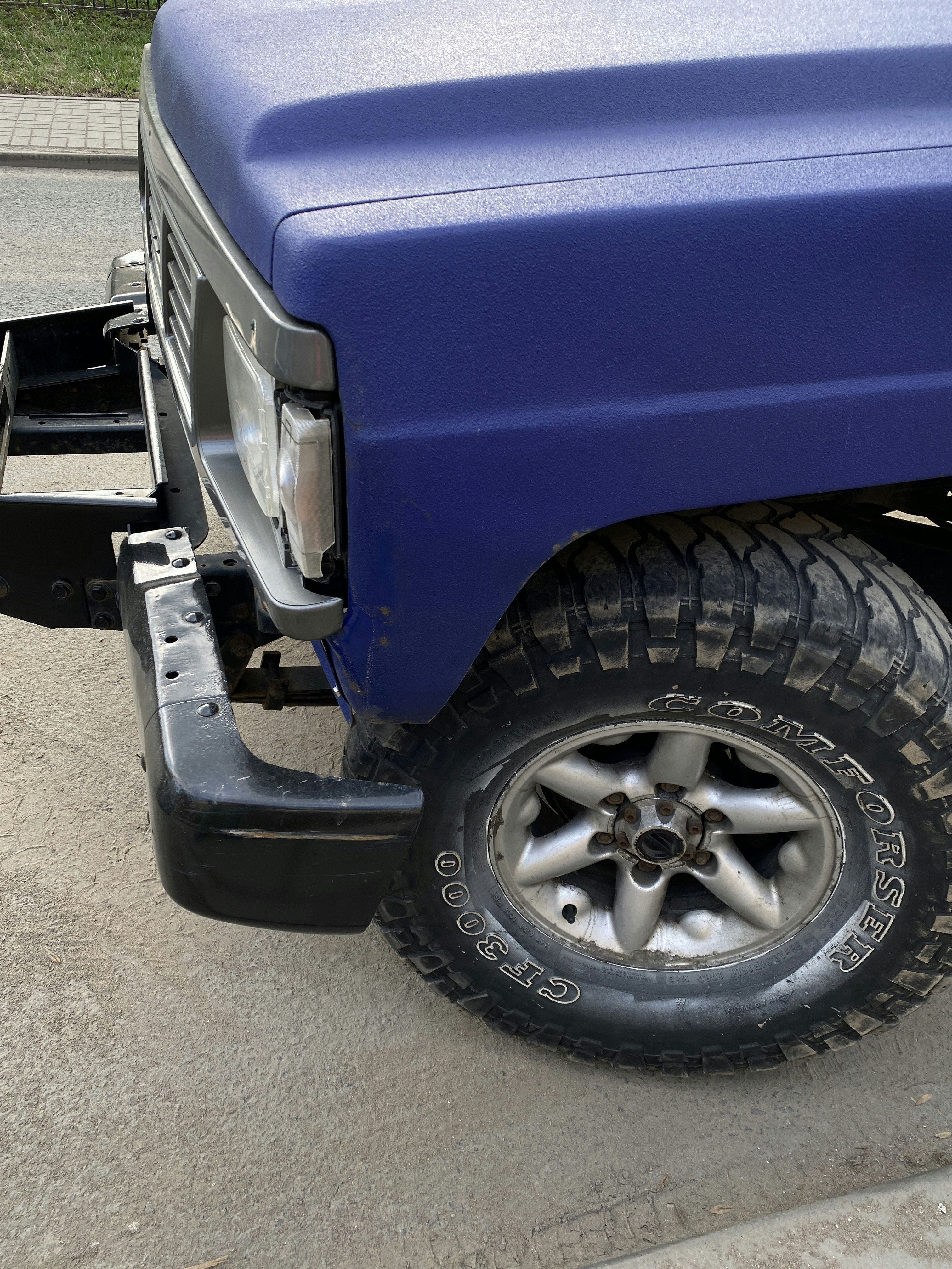 Rugged Blue Front: Close-Up of Wheel, Tire, and Fender on an Off-Road Truck