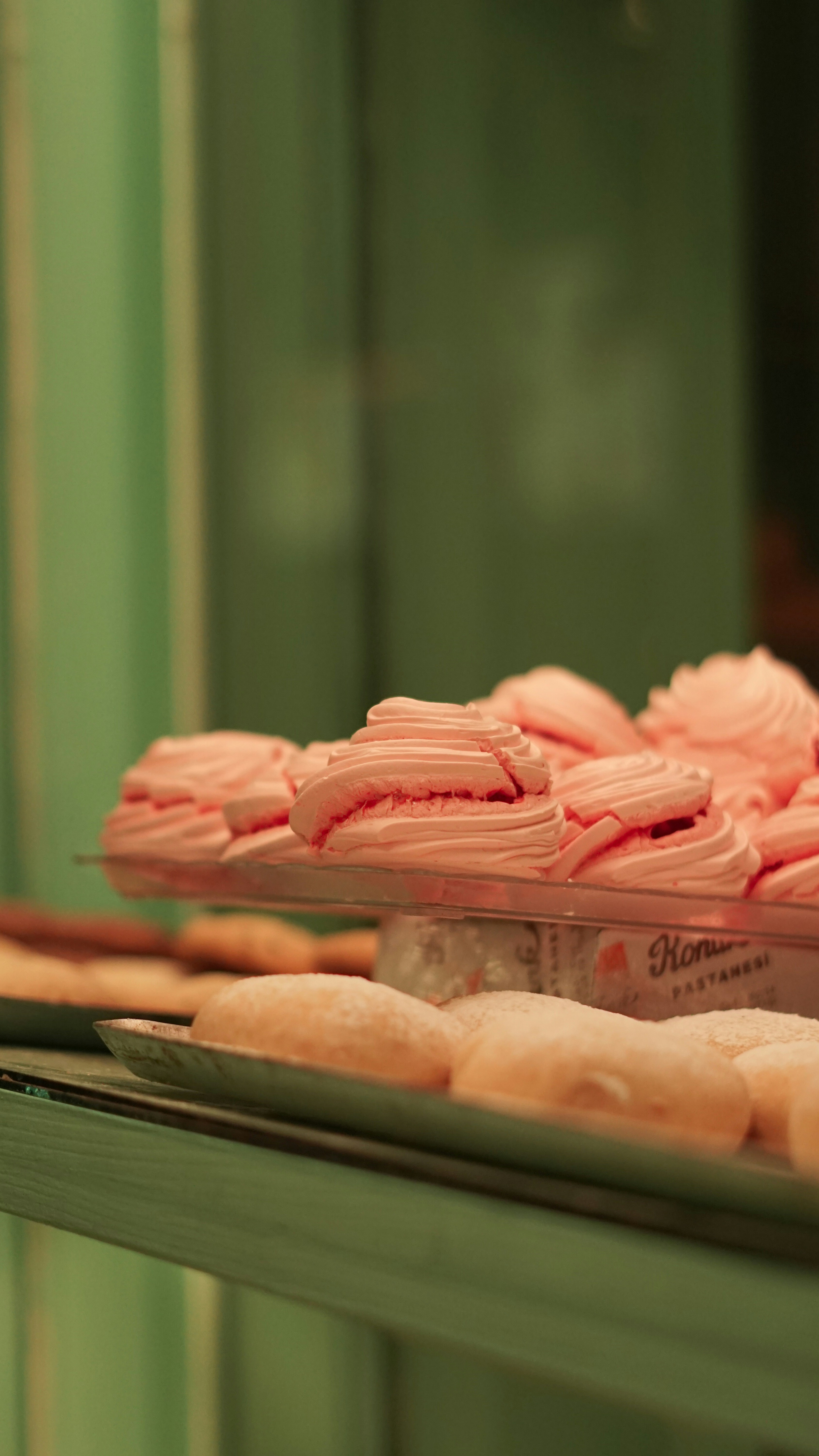 Pastel Crescendo: Pink Macarons in a Quiet Bakery Display