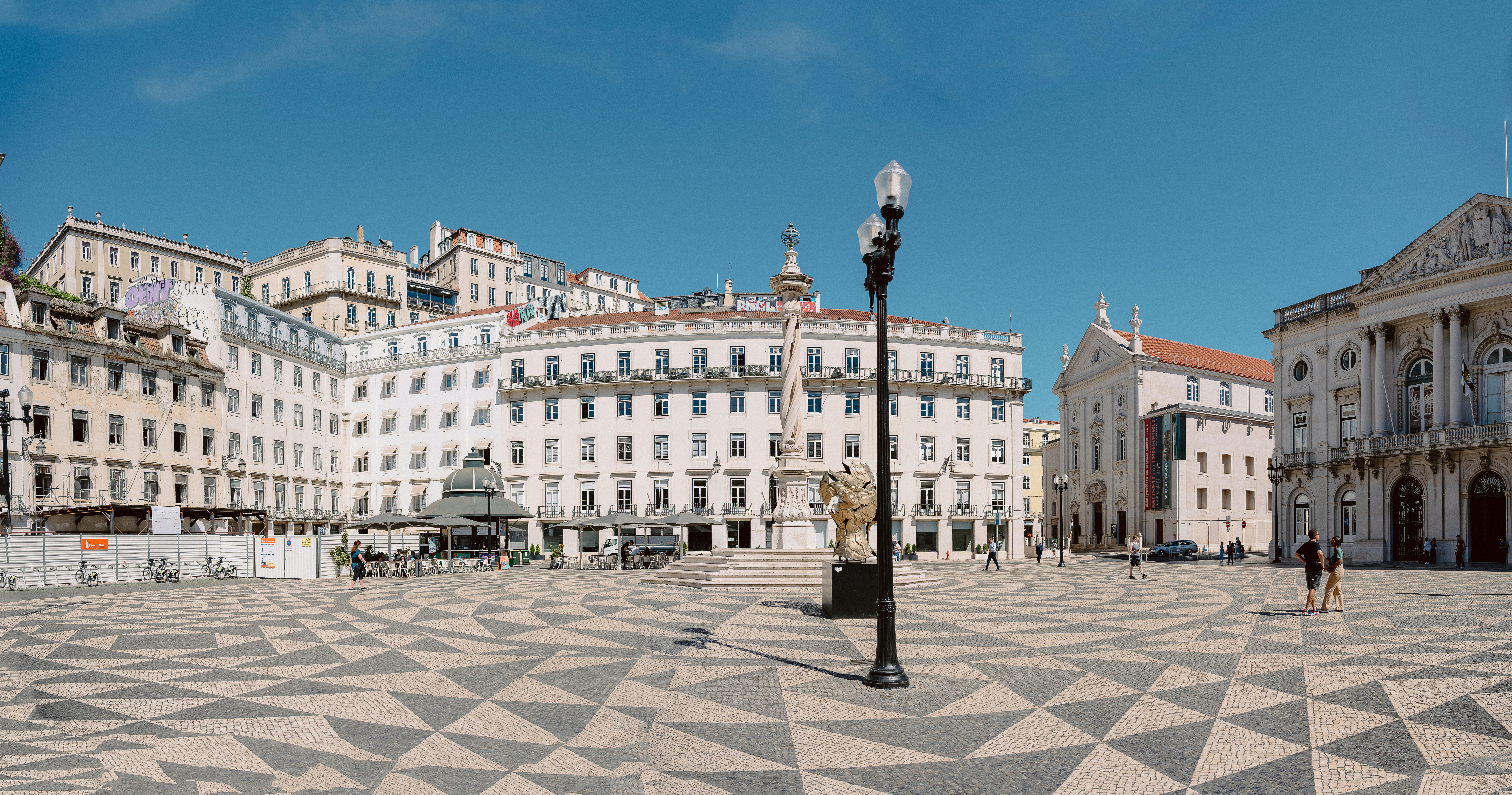 A city square with people walking around and buildings in the ...