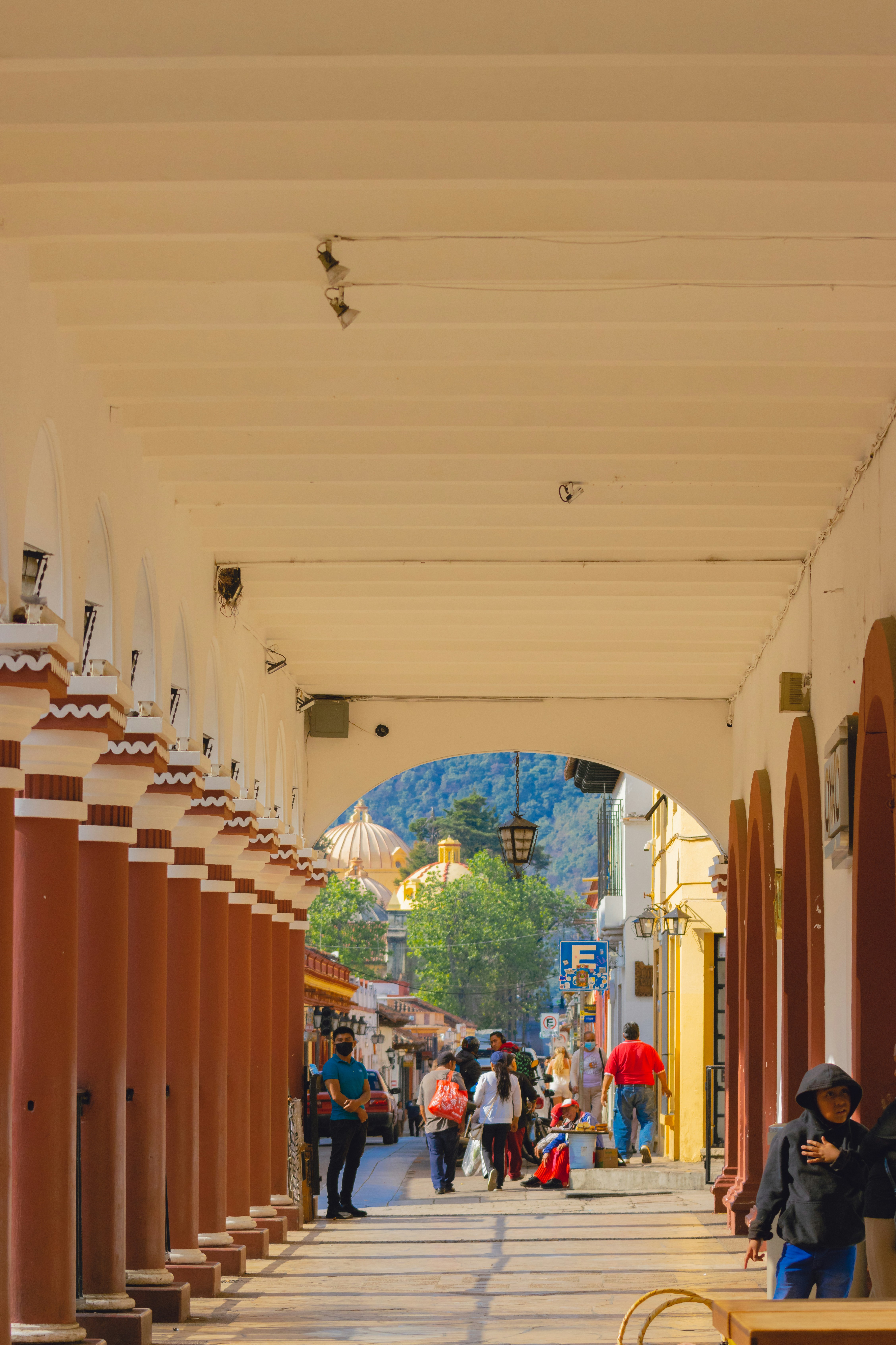 Arcade of Arches: A Sunlit Walk Toward a Mountain Town