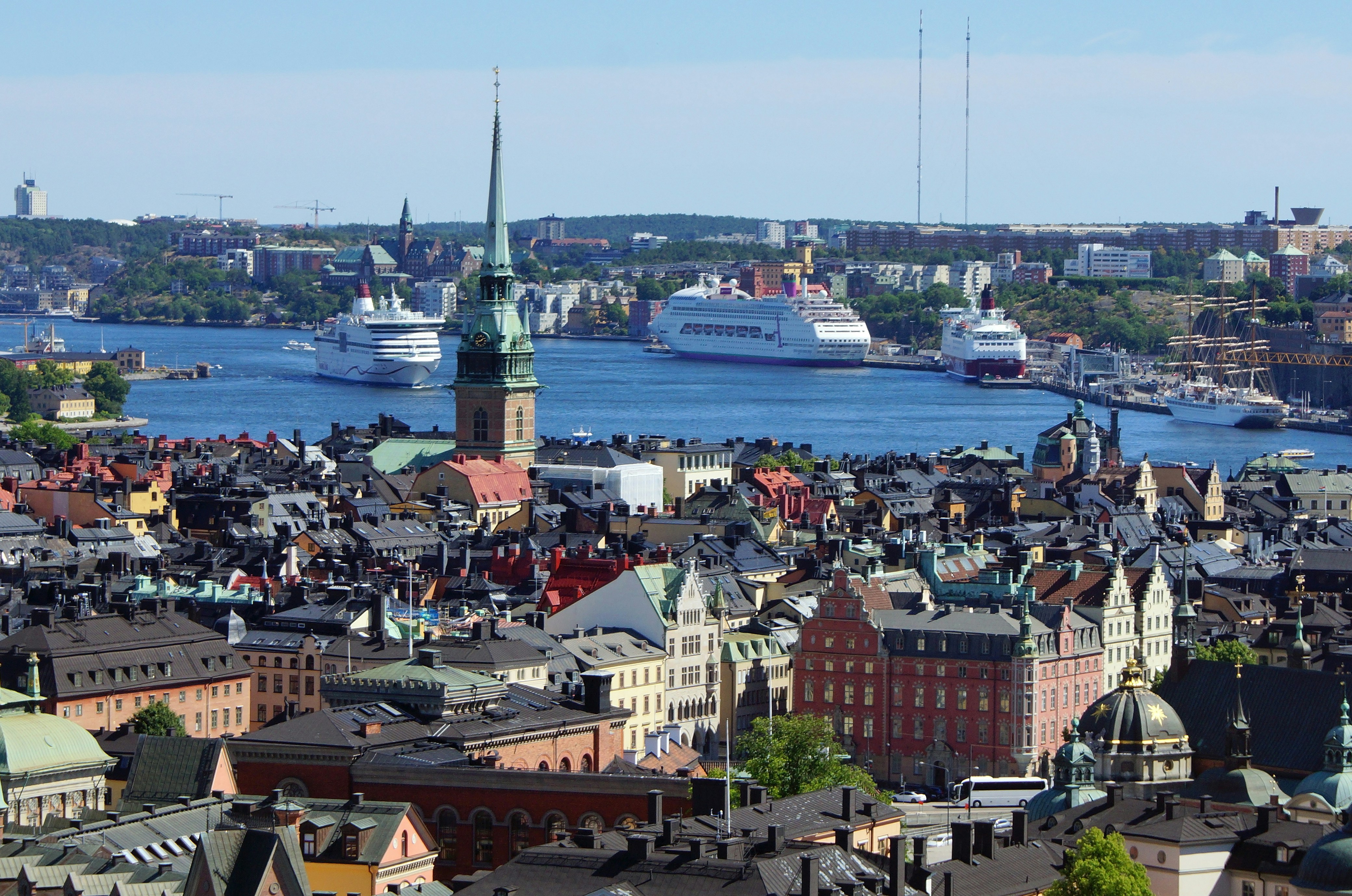 Skyline of Stockholm on a sunny summer day with several big cruise liners in the background.