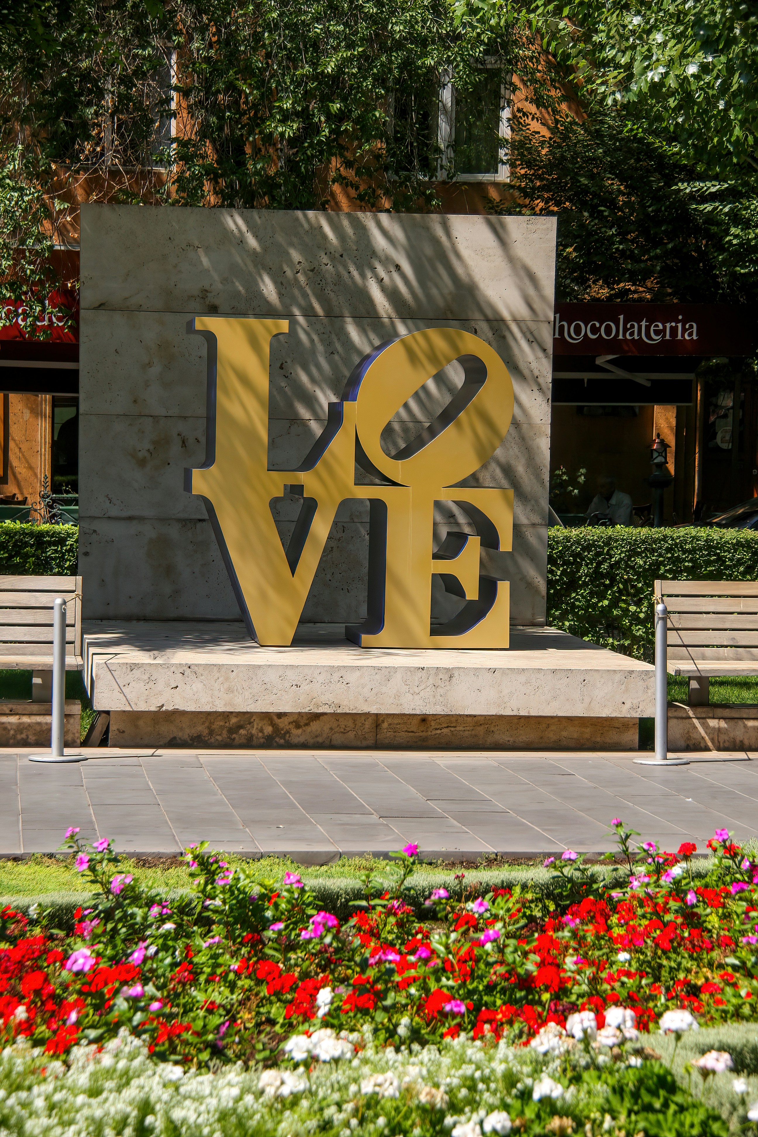 Love on Light: The Golden LOVE Sculpture in a Sunlit Urban Plaza