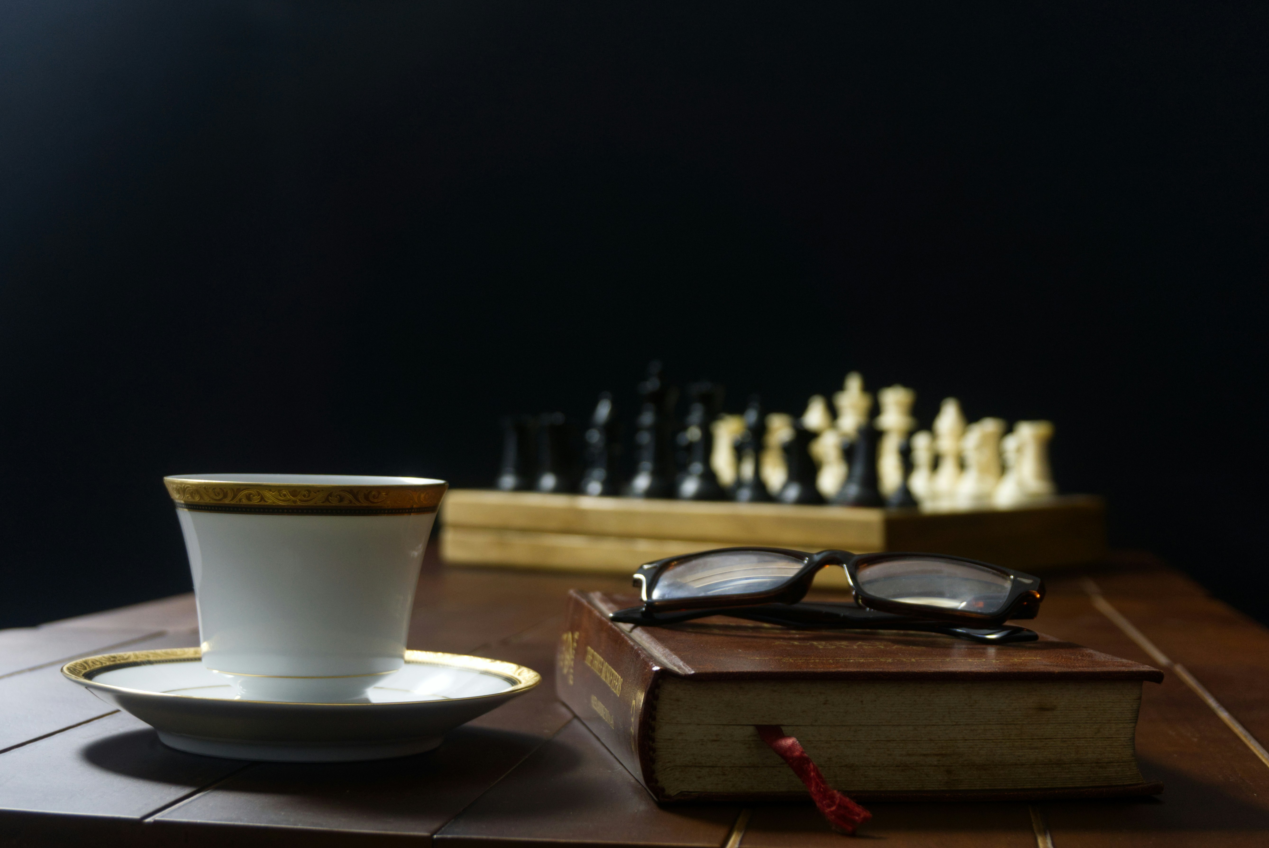 A cup of coffee next to a book and a chess set photo – Free Table Image ...