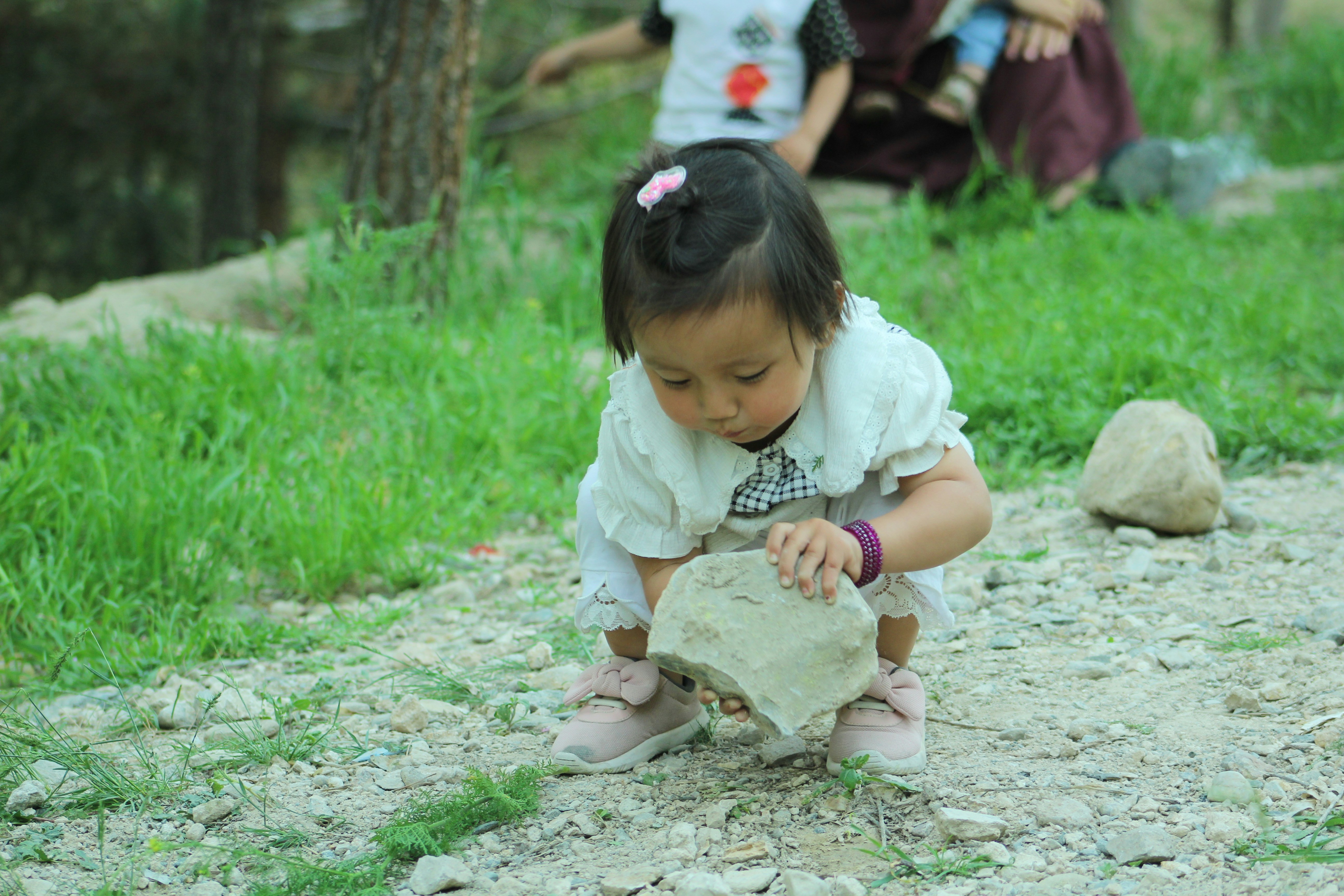 Tiny Stone Architect: A Curious Toddler at Ground Level