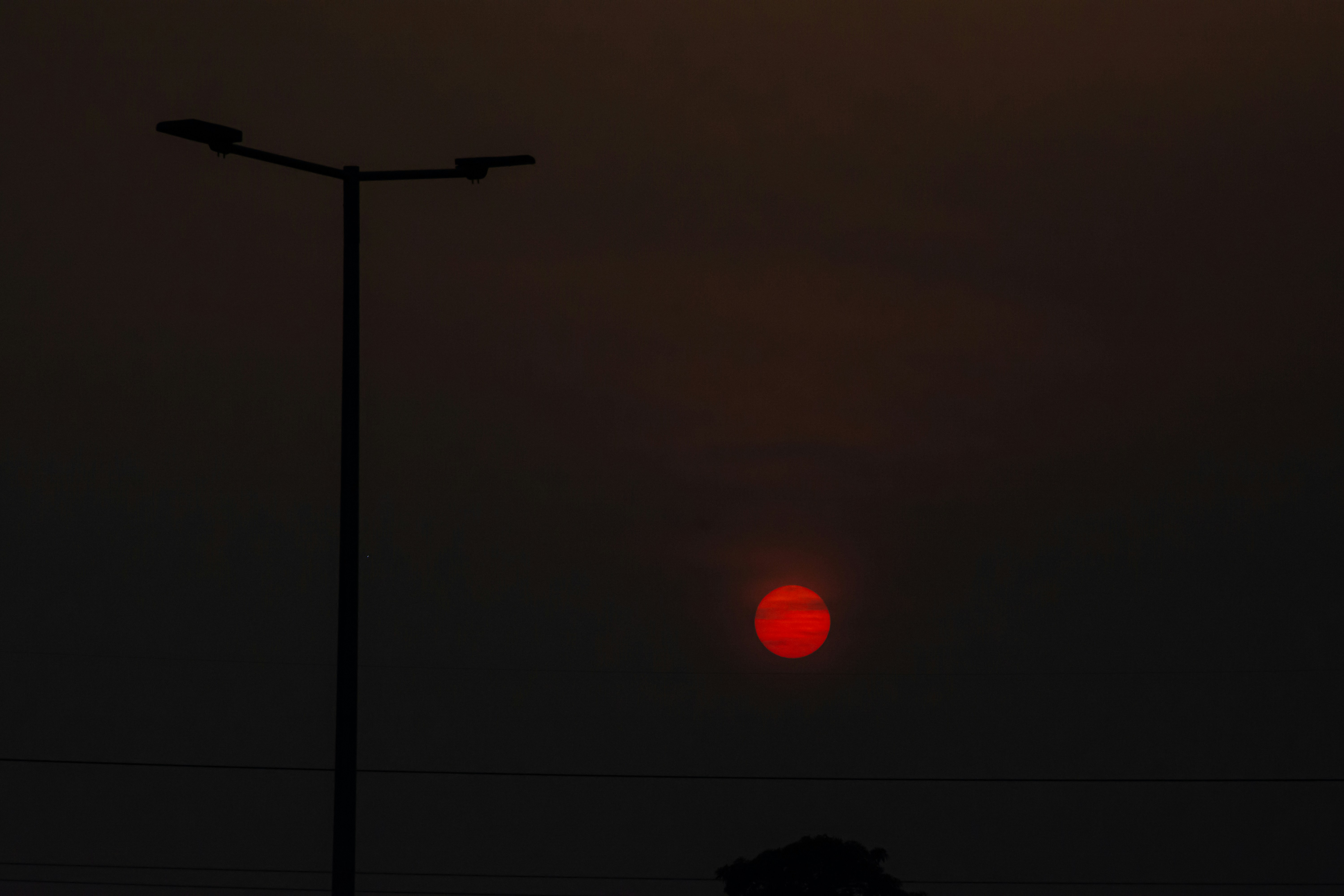 Crimson Sun Between Urban Silhouettes at Dusk