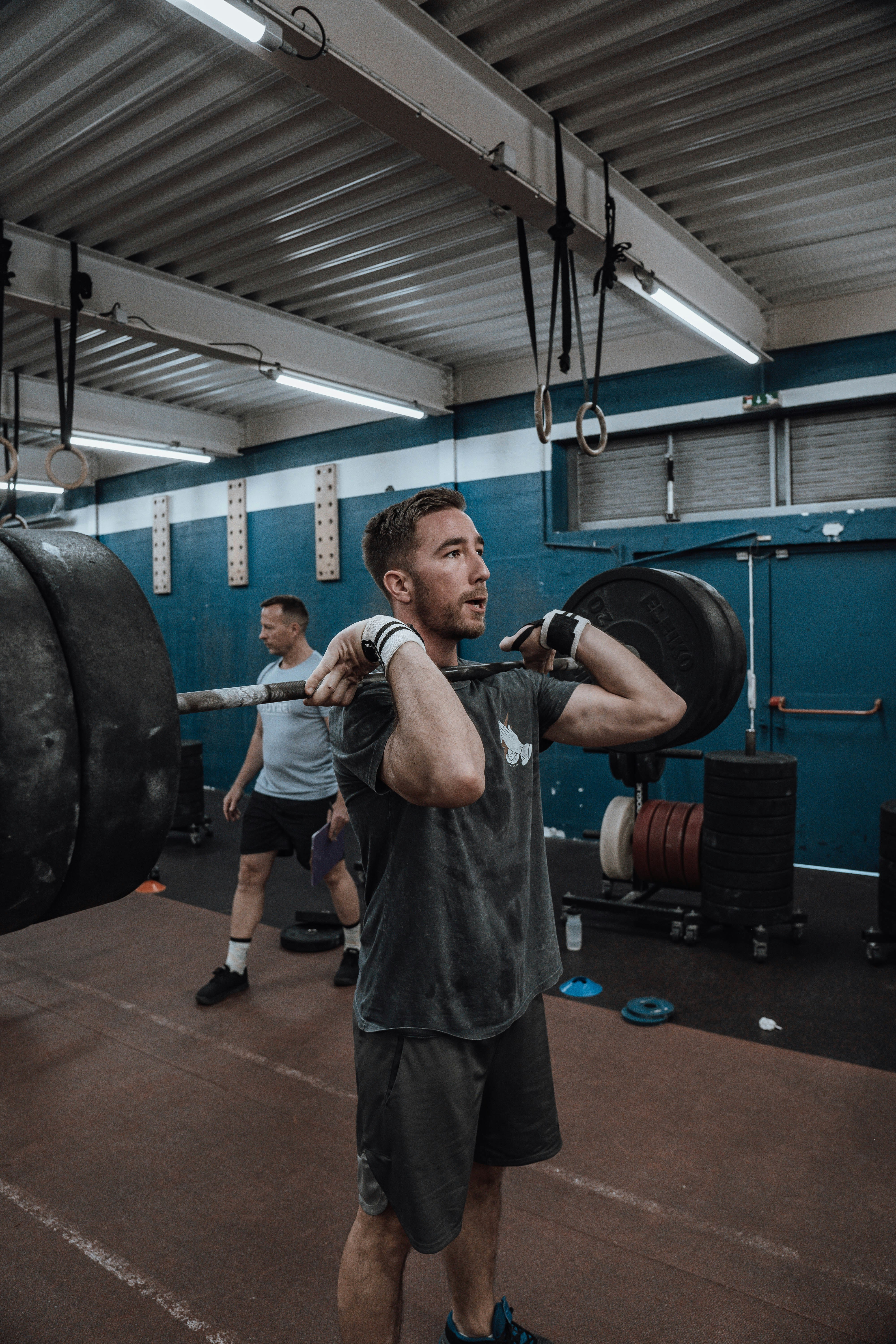 A man holding a barbell in a gym photo – Free Man Image on Unsplash