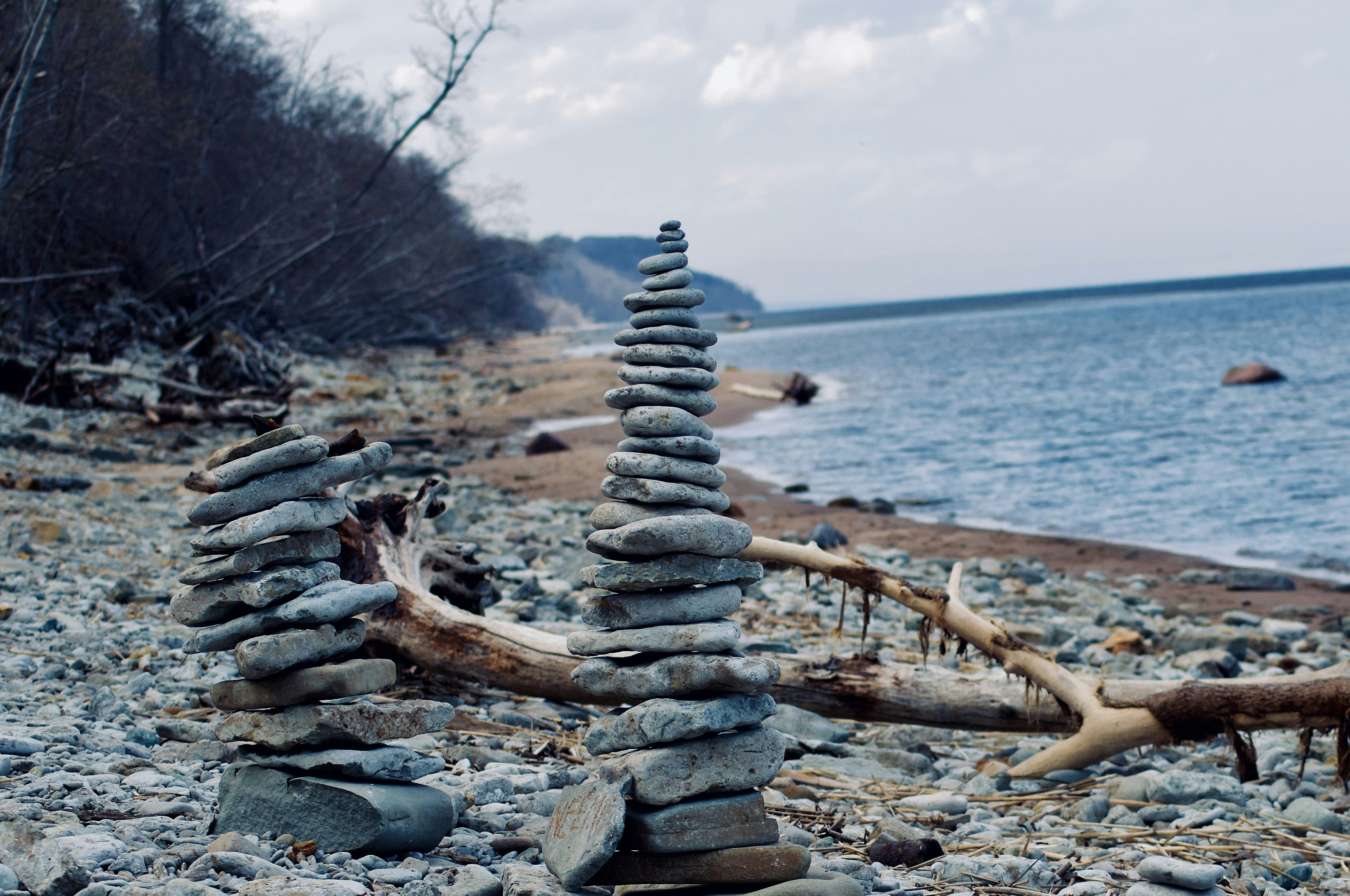 Cairn Guardians: Stacked Stones Mark a Pebble Beach by a Quiet Lake