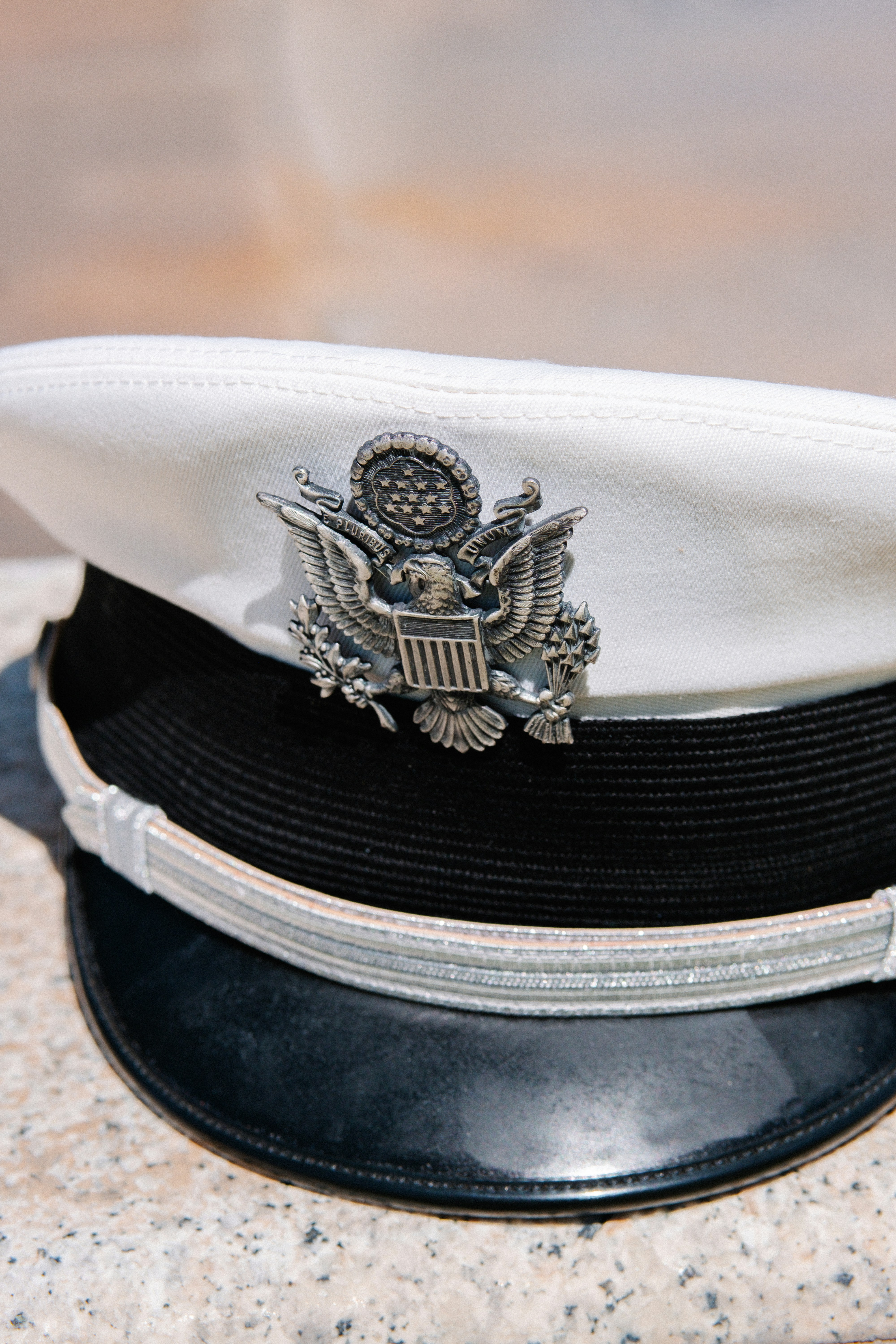 White Naval Cap with Emblem resting on Black Peak