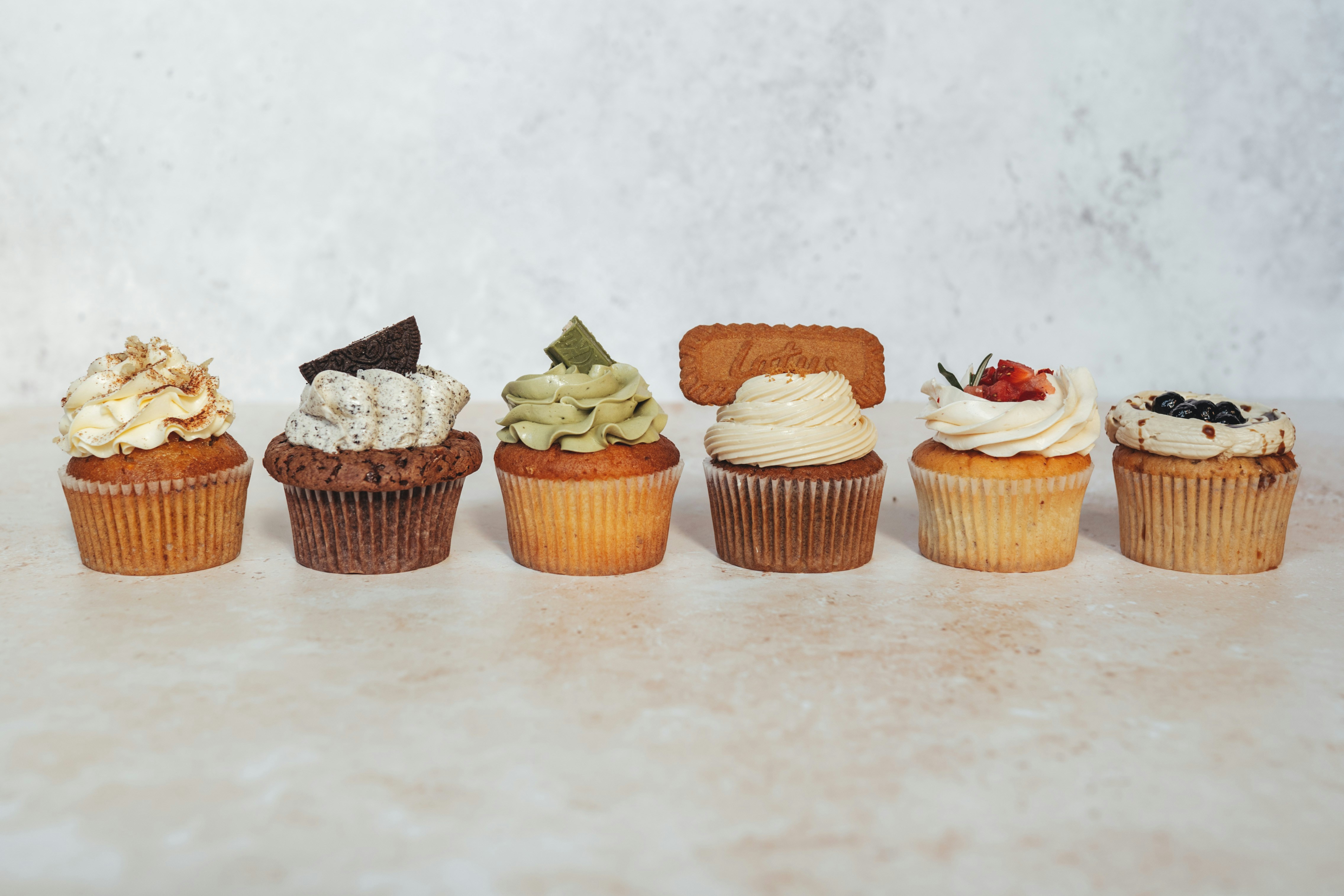Seven Frosted Minis Aligned on a Pale Marble Stage