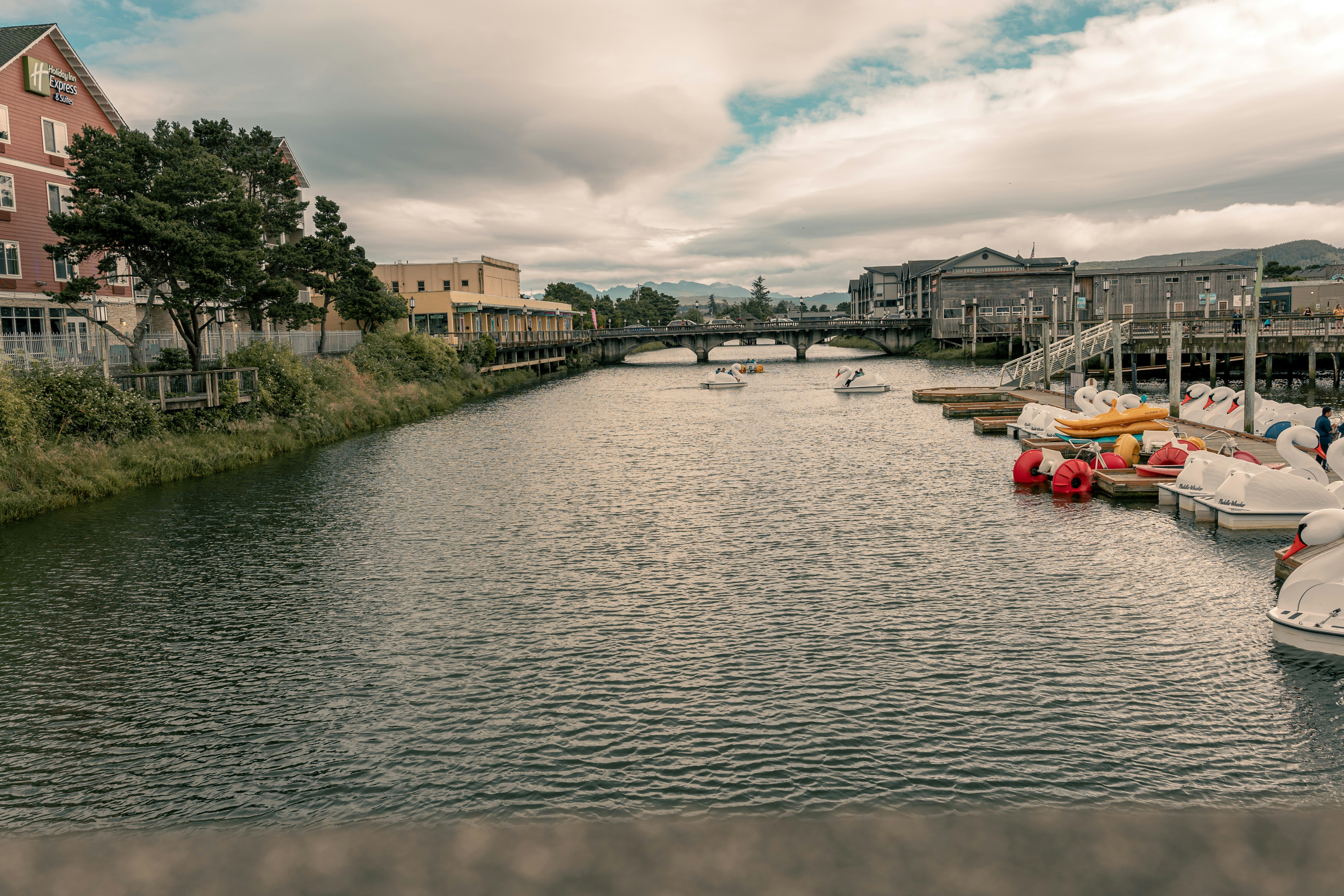 Quiet Canal Corridor: Boats Lounging by a Red-Brick Townscape Under Soft Clouds