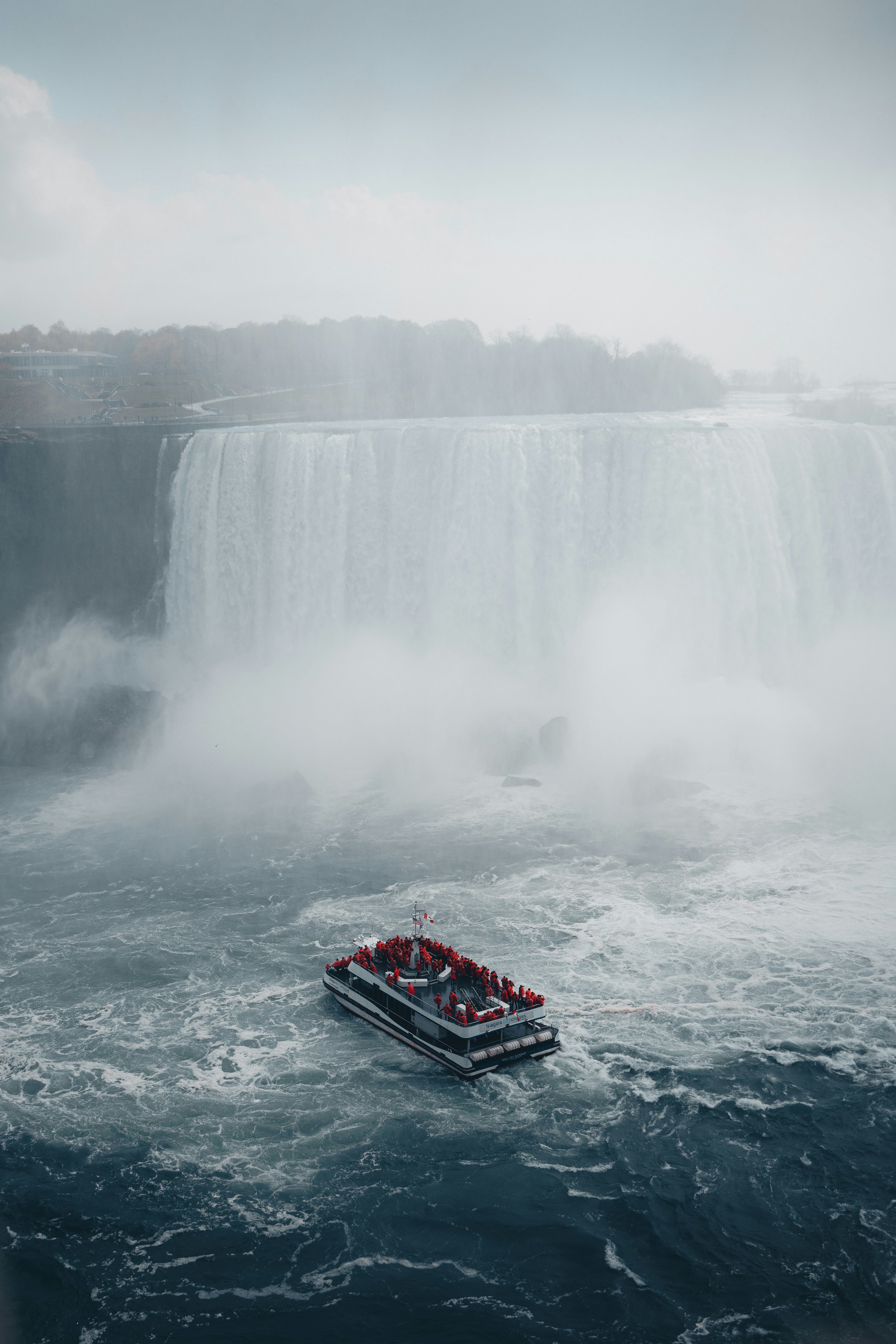 Red-clad Tour Boat Confronts Niagara’s Brink in a Veil of Mist