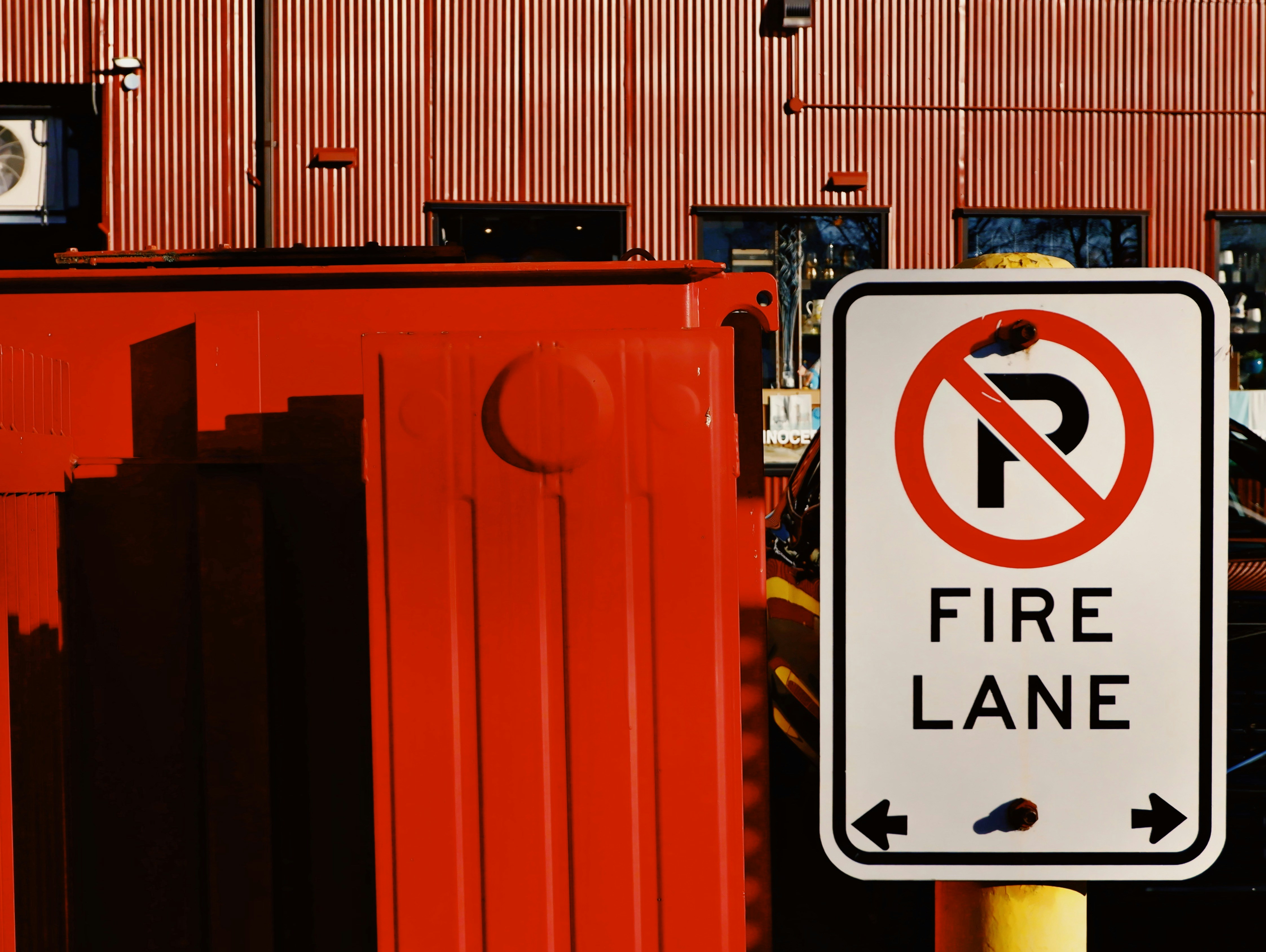 A no parking fire lane sign in front of a red building photo – Free ...