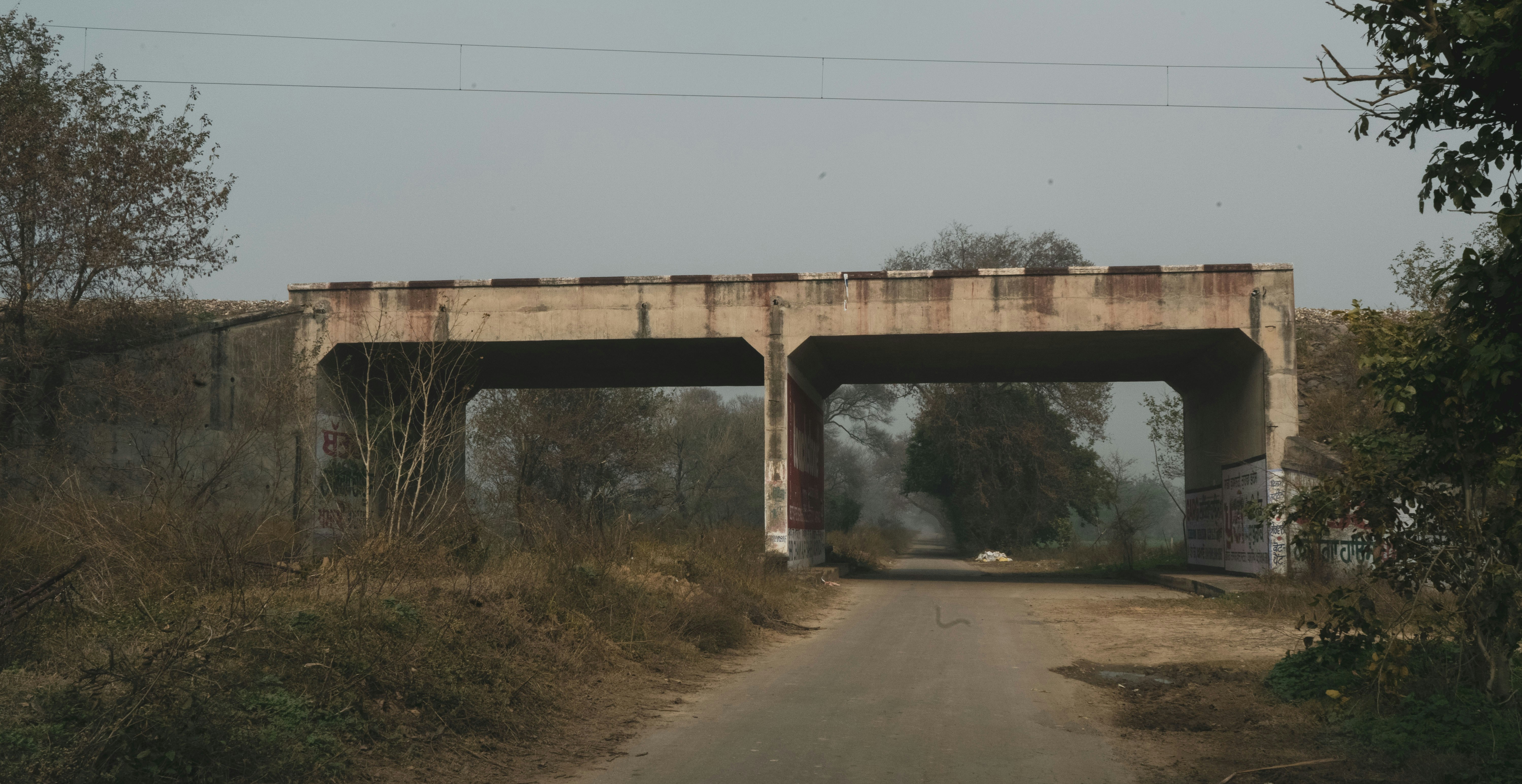 Approaching Silence Beneath a Weathered Concrete Bridge