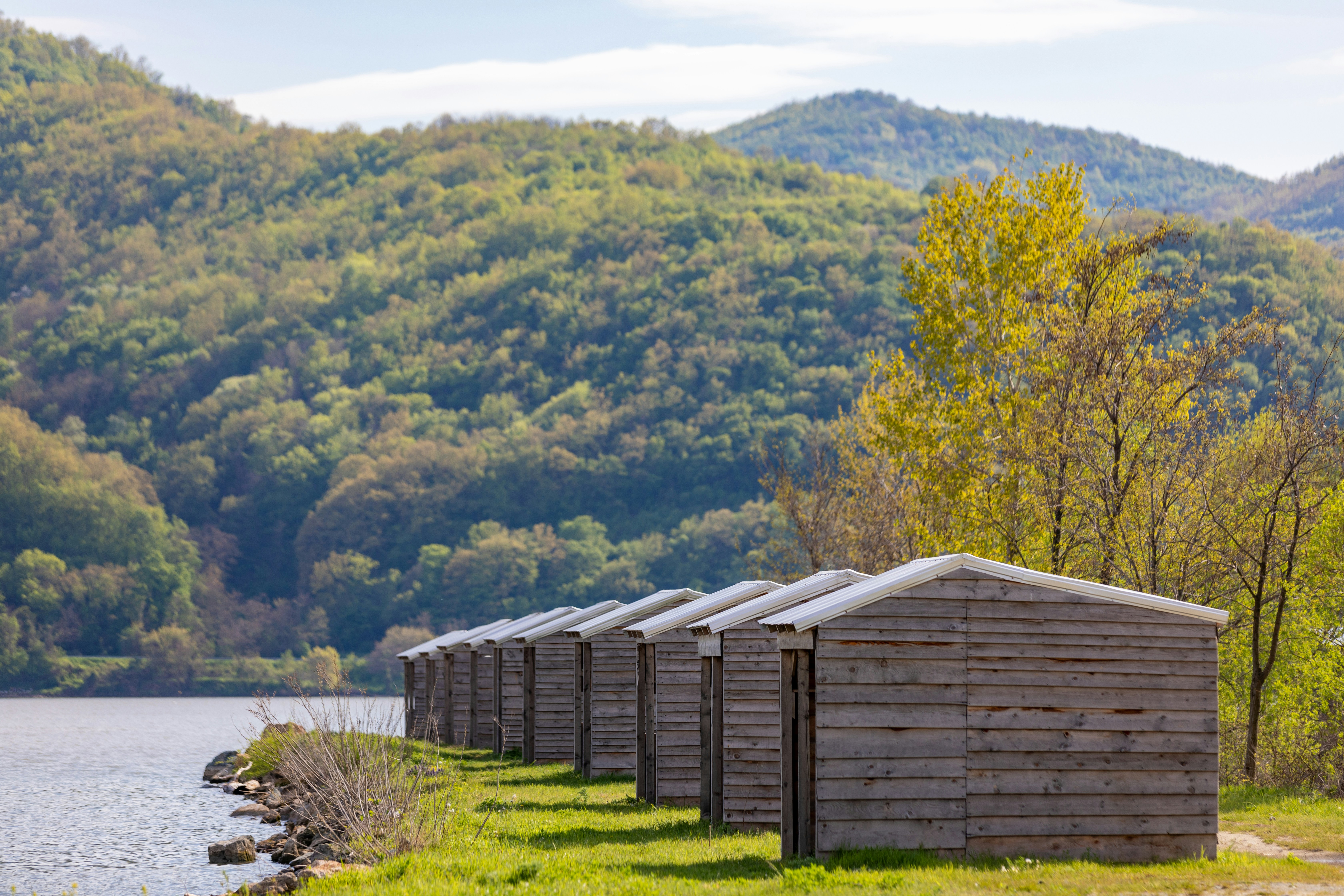 Una hilera de cabañas de madera sentadas junto a un lago foto – Imagen ...