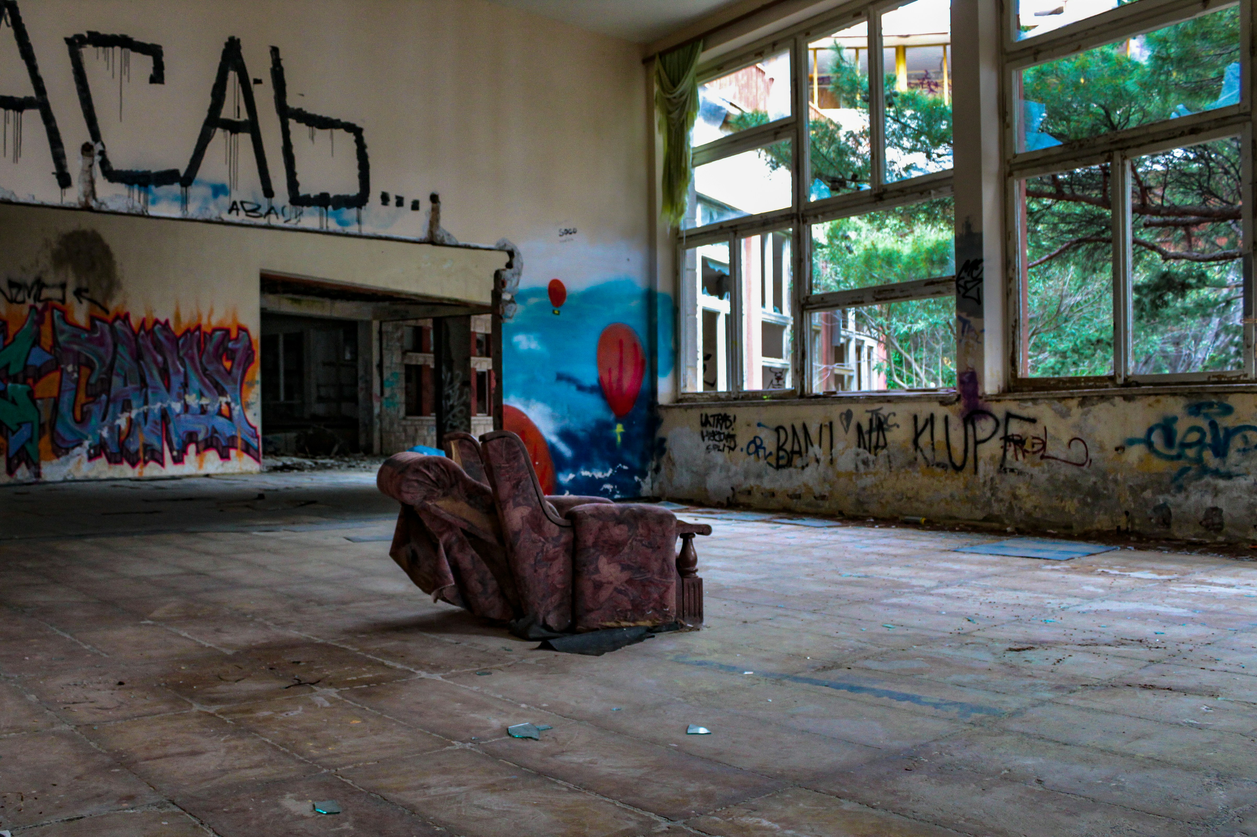 Abandoned Armchair Repose under Graffitied Windows