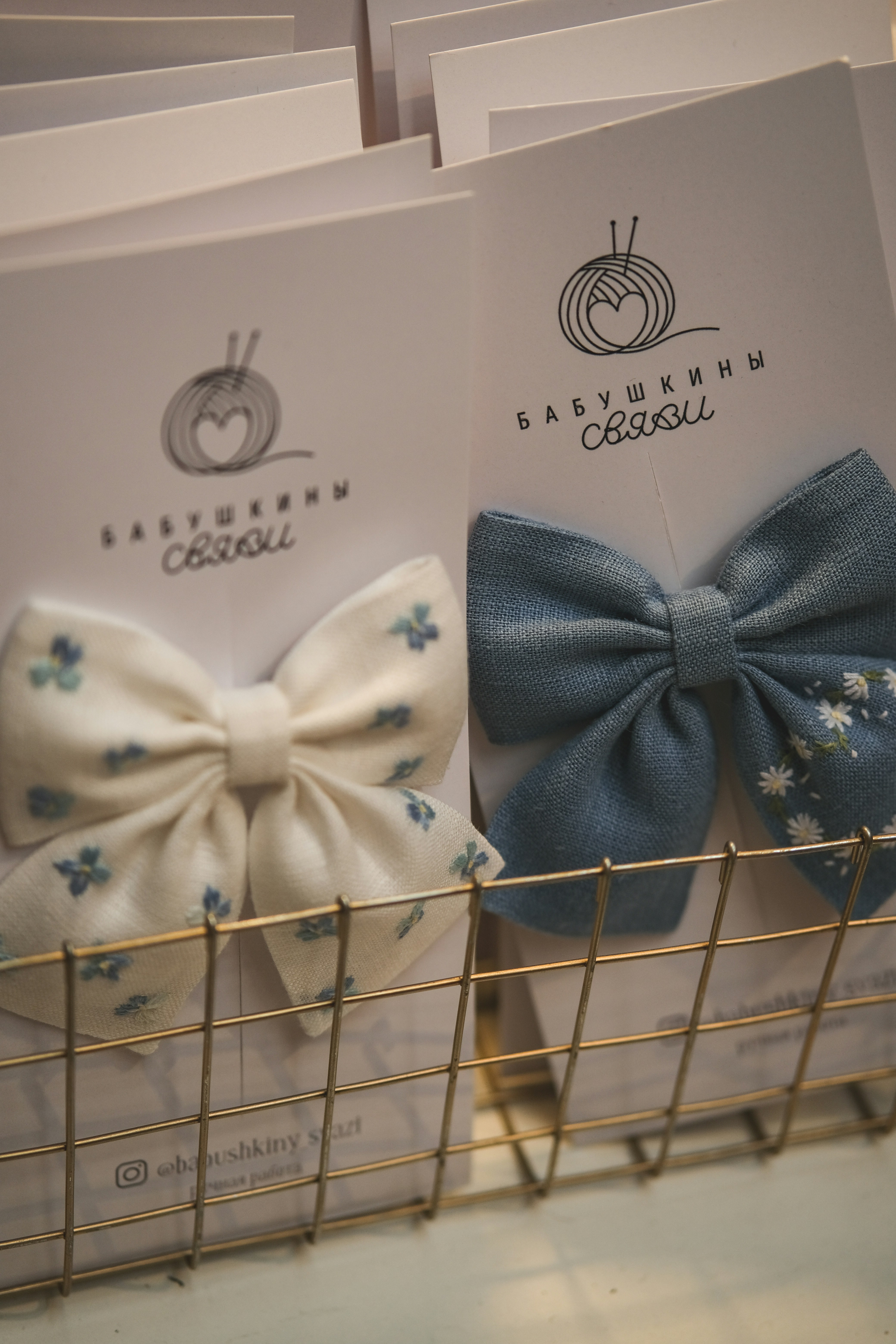 Two beautifully crafted hair bows displayed on elegant cards, showcasing intricate designs and soft fabrics.