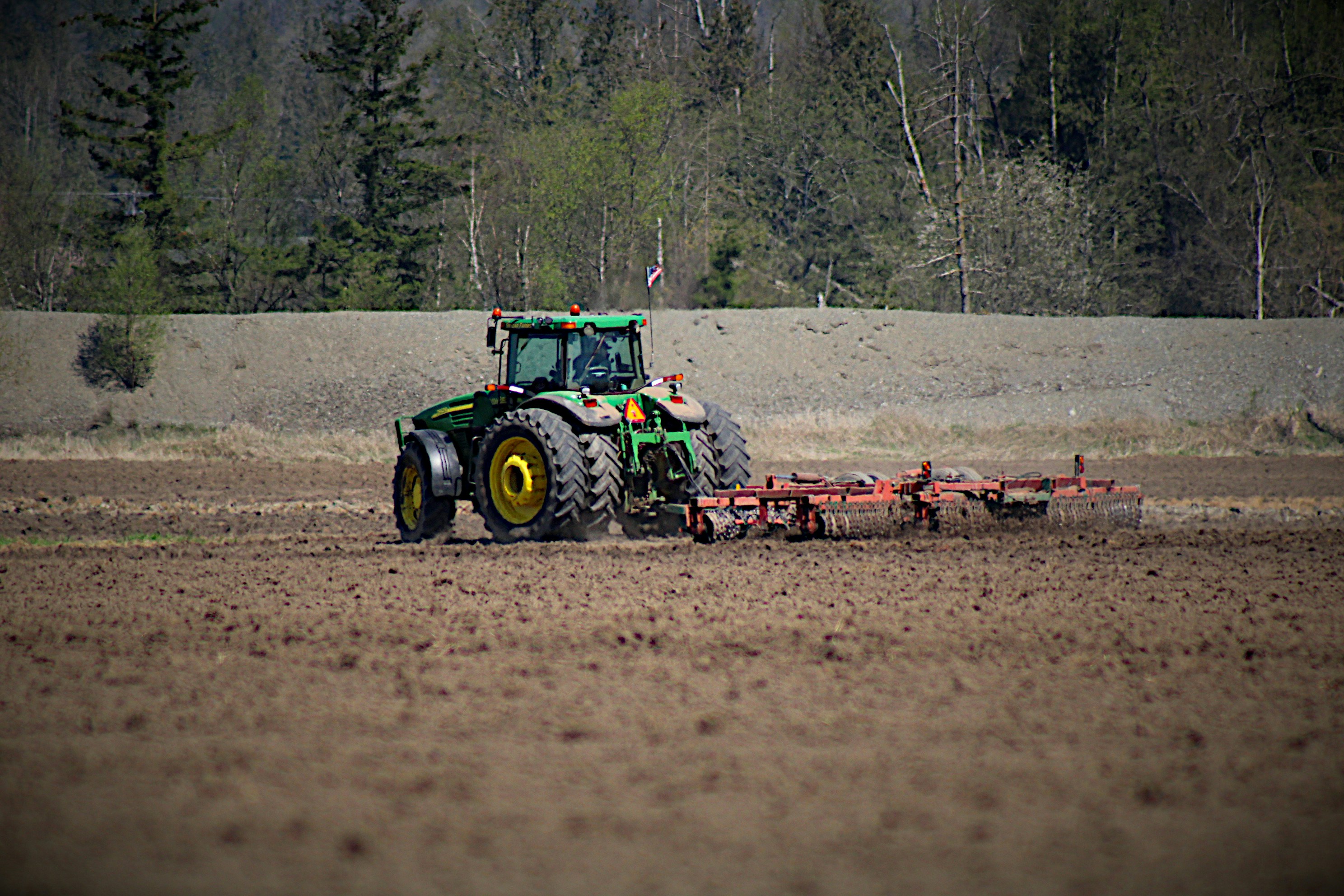 A tractor plowing a field with a plow photo – Free Tractor Image on ...