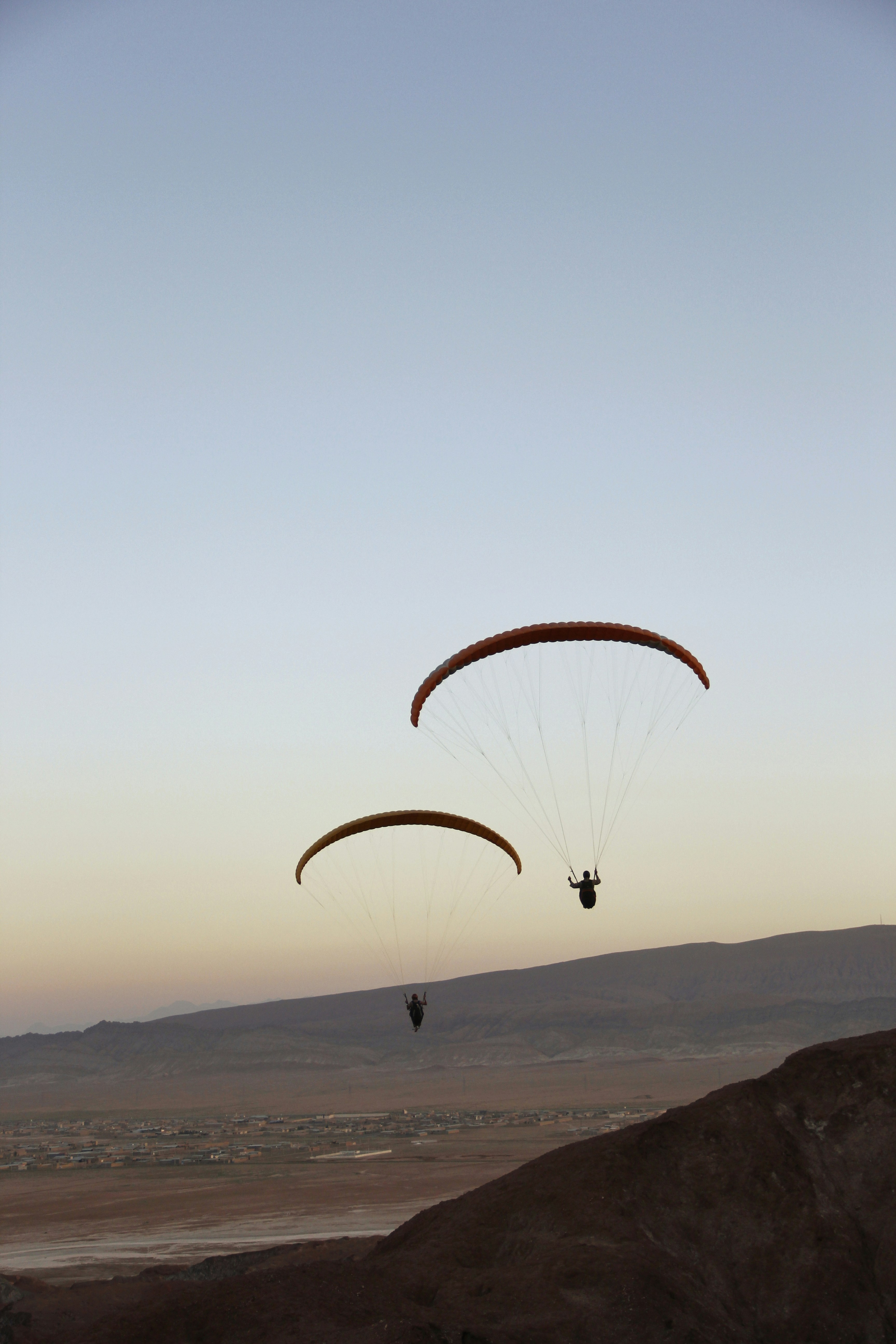 Desert Dusk: Paragliders Sweep Across a Silhouetted Ridge