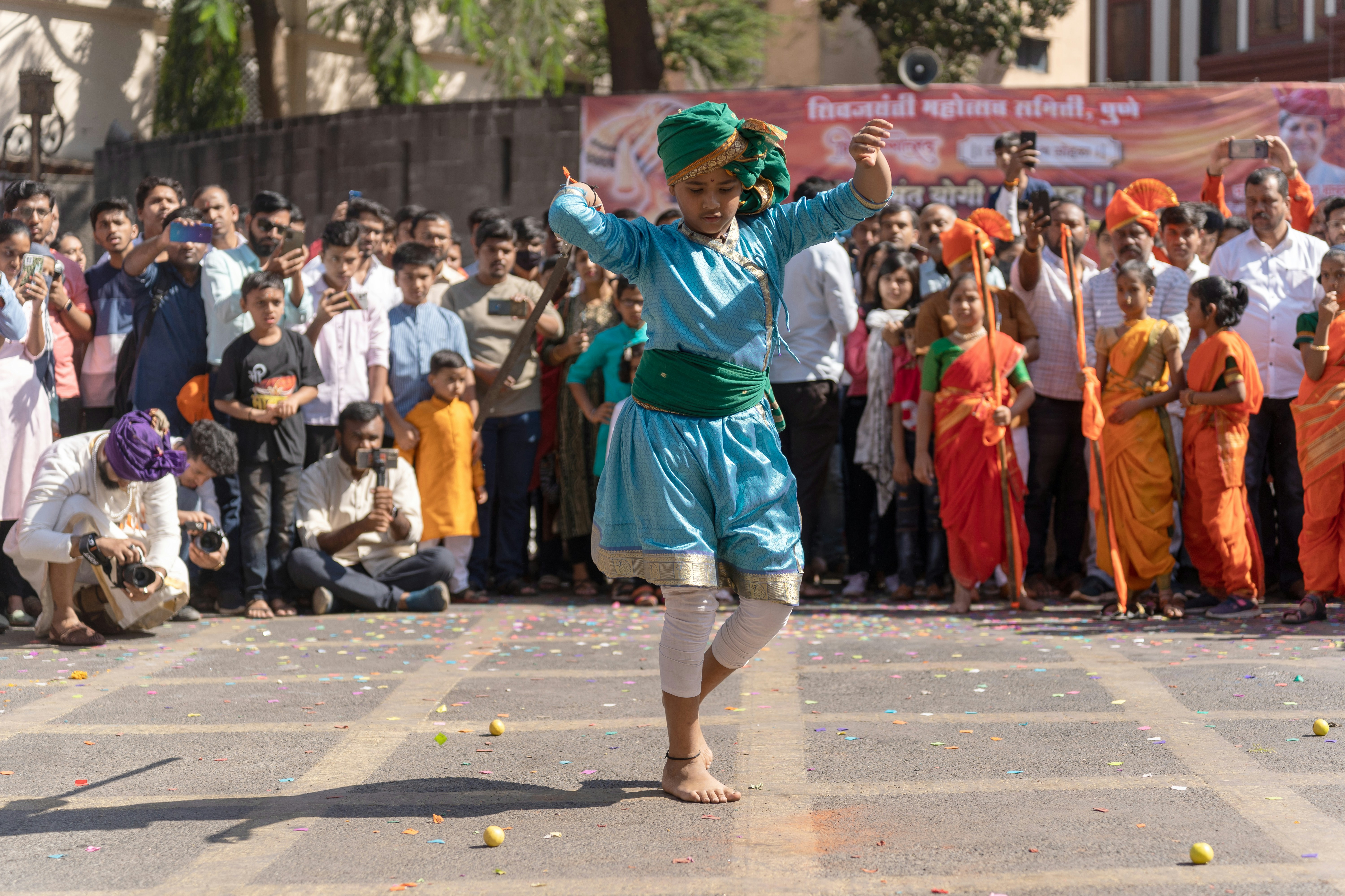 Performer in traditional attire dances energetically before a crowd during Shiv Jayanti celebrations.