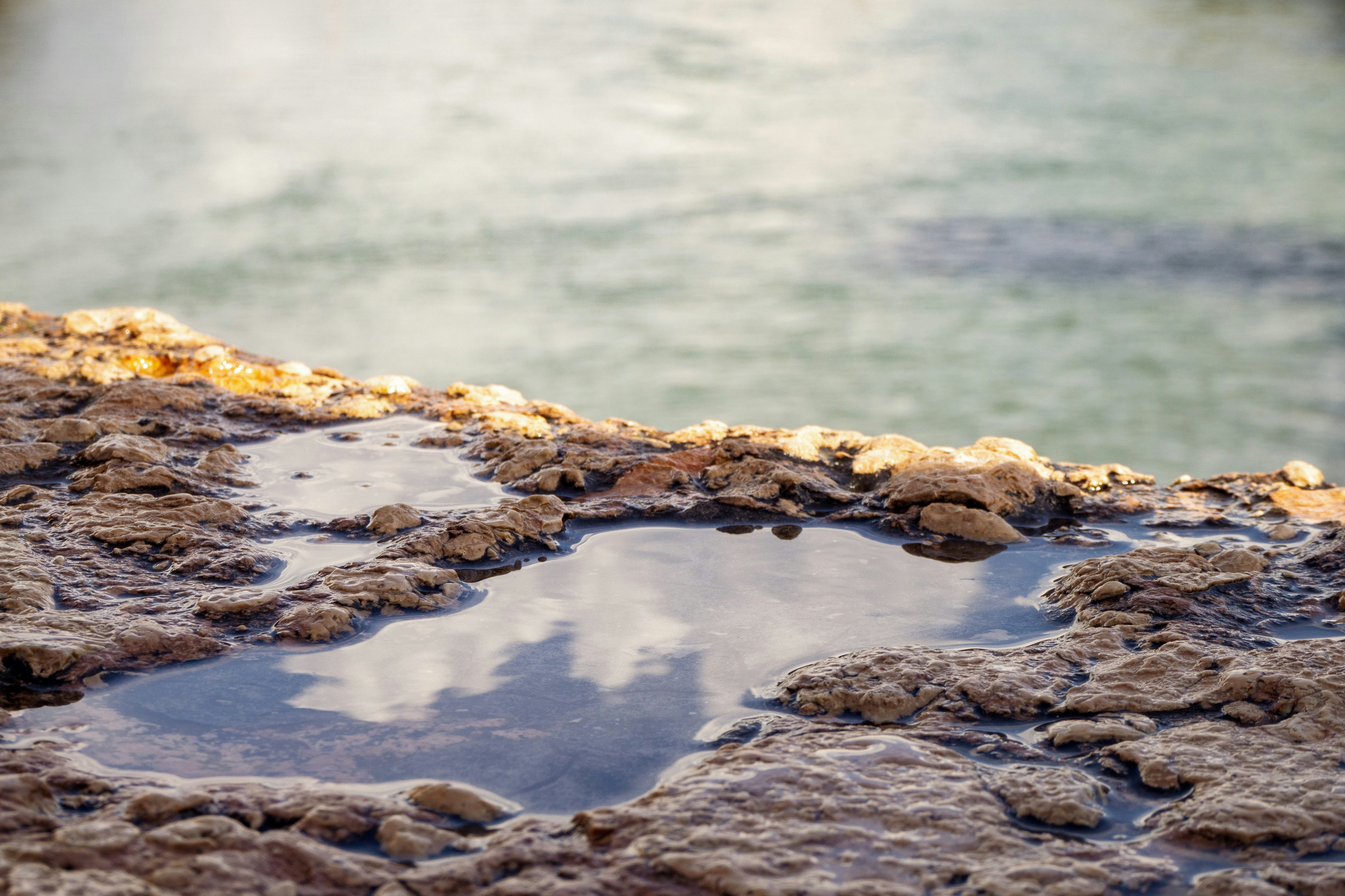 A puddle of water that is next to a body of water photo – Free River ...