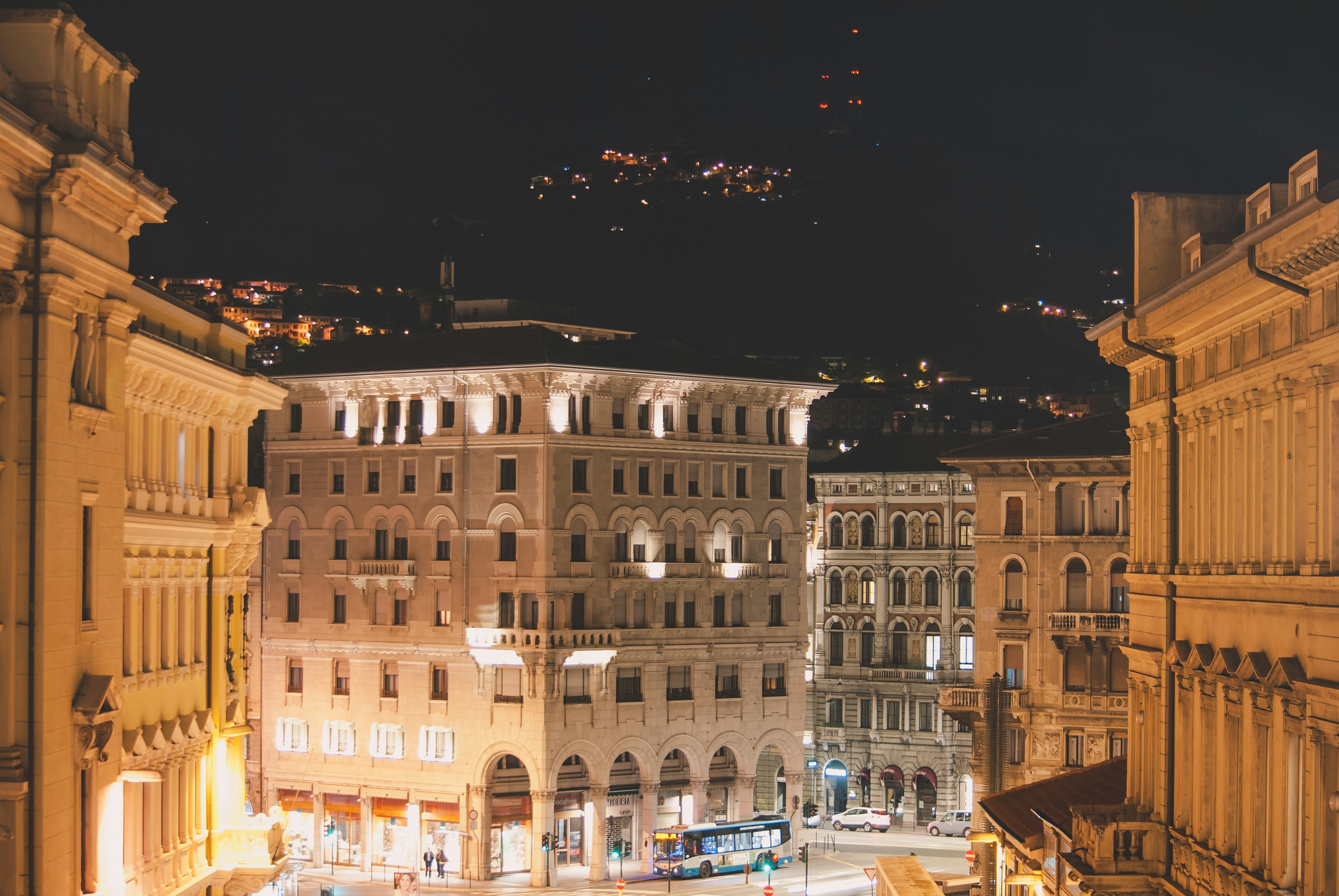 Arched Piazza at Night: Warm Facades Framing a Hilltop Glow