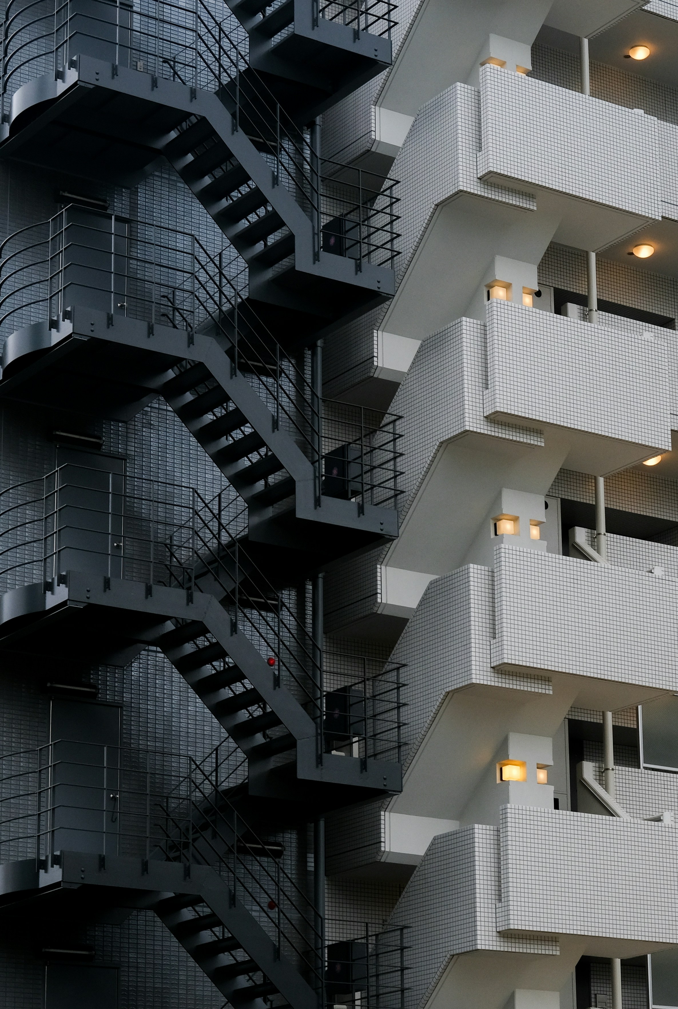 Vertical Contrast: Steel Stairs Meet White Tile Facades