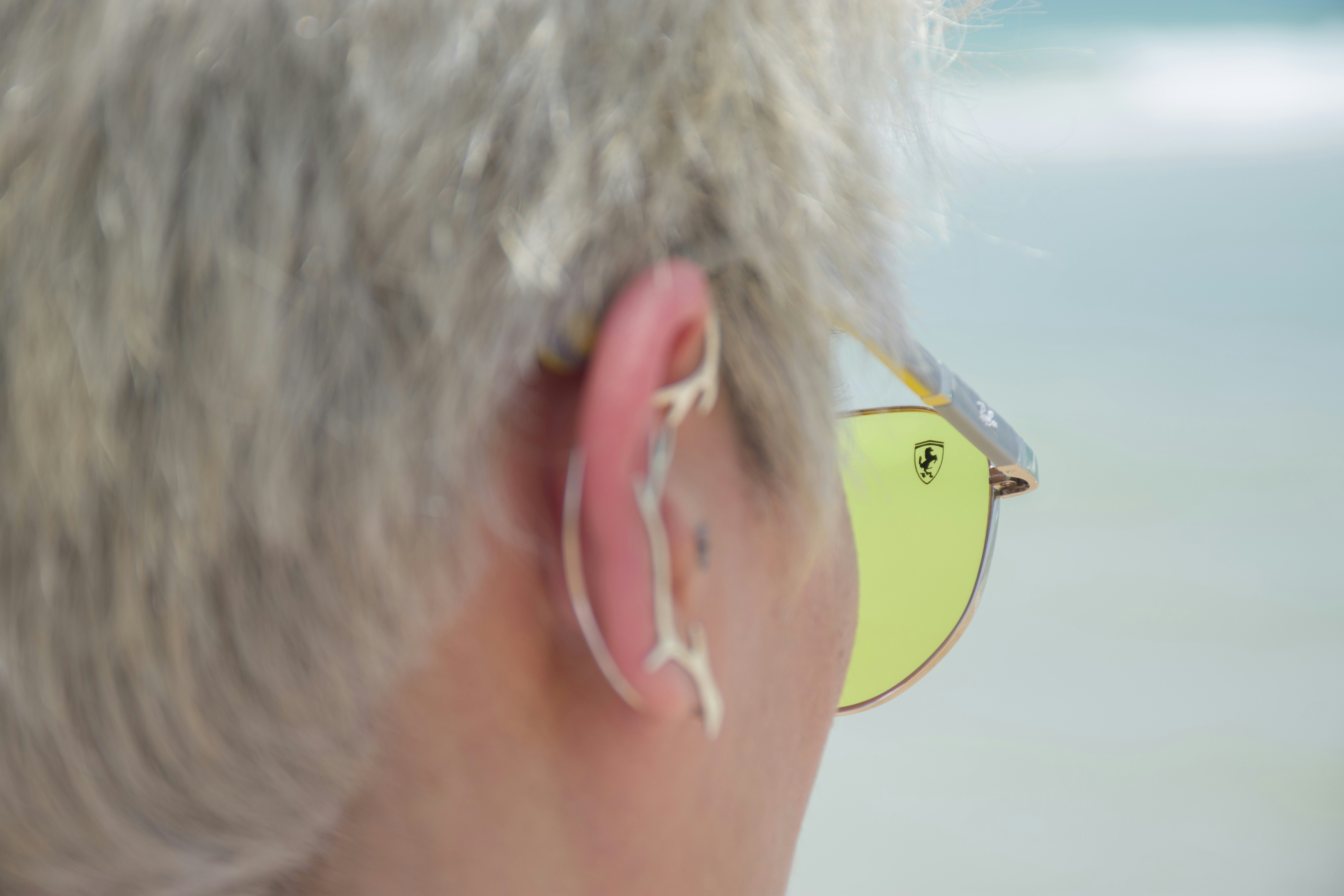 Glint of Style: Sunglass Reflection and Neon Hair at the Shore