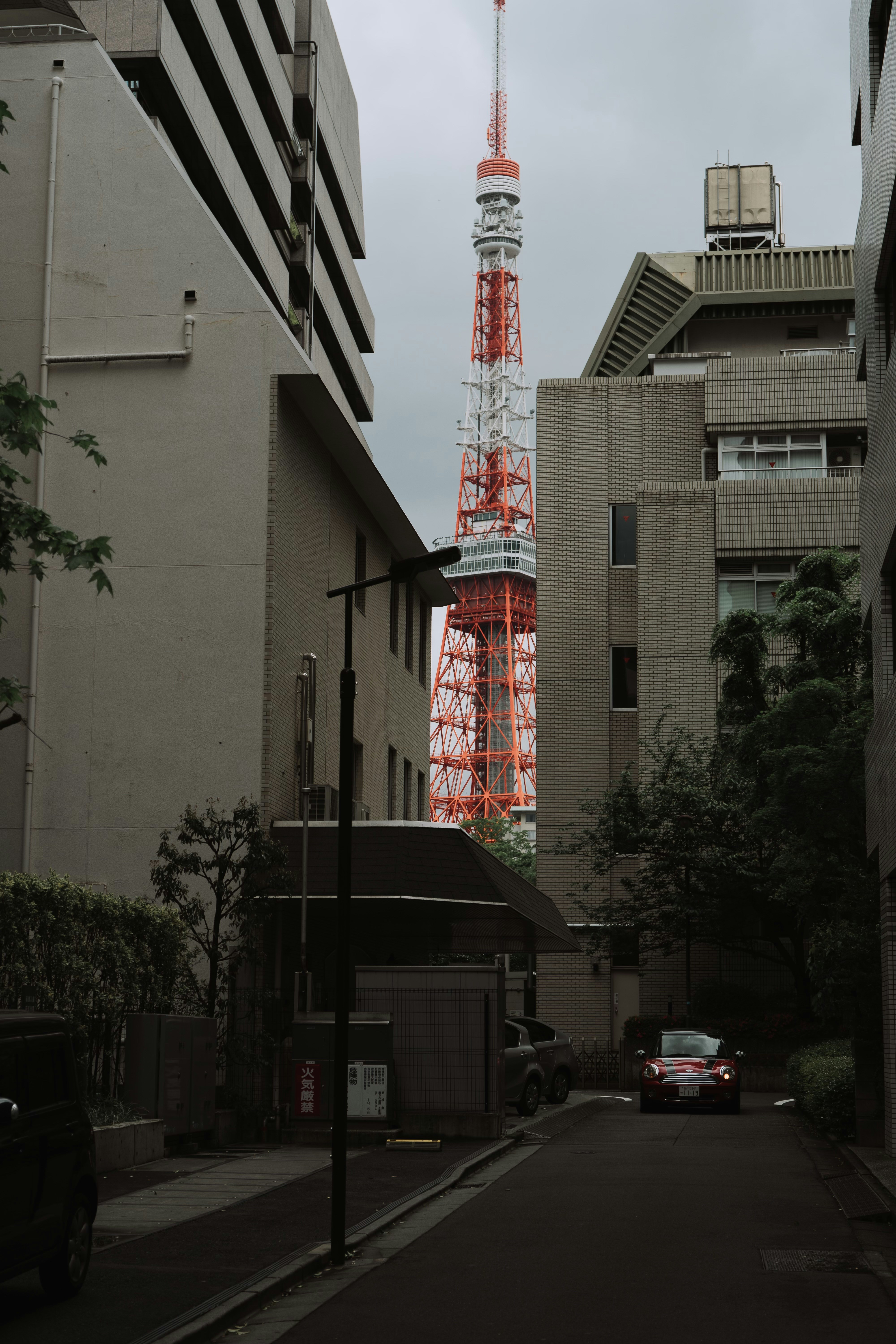 A picture of Tokyo tower peeking through two buildings