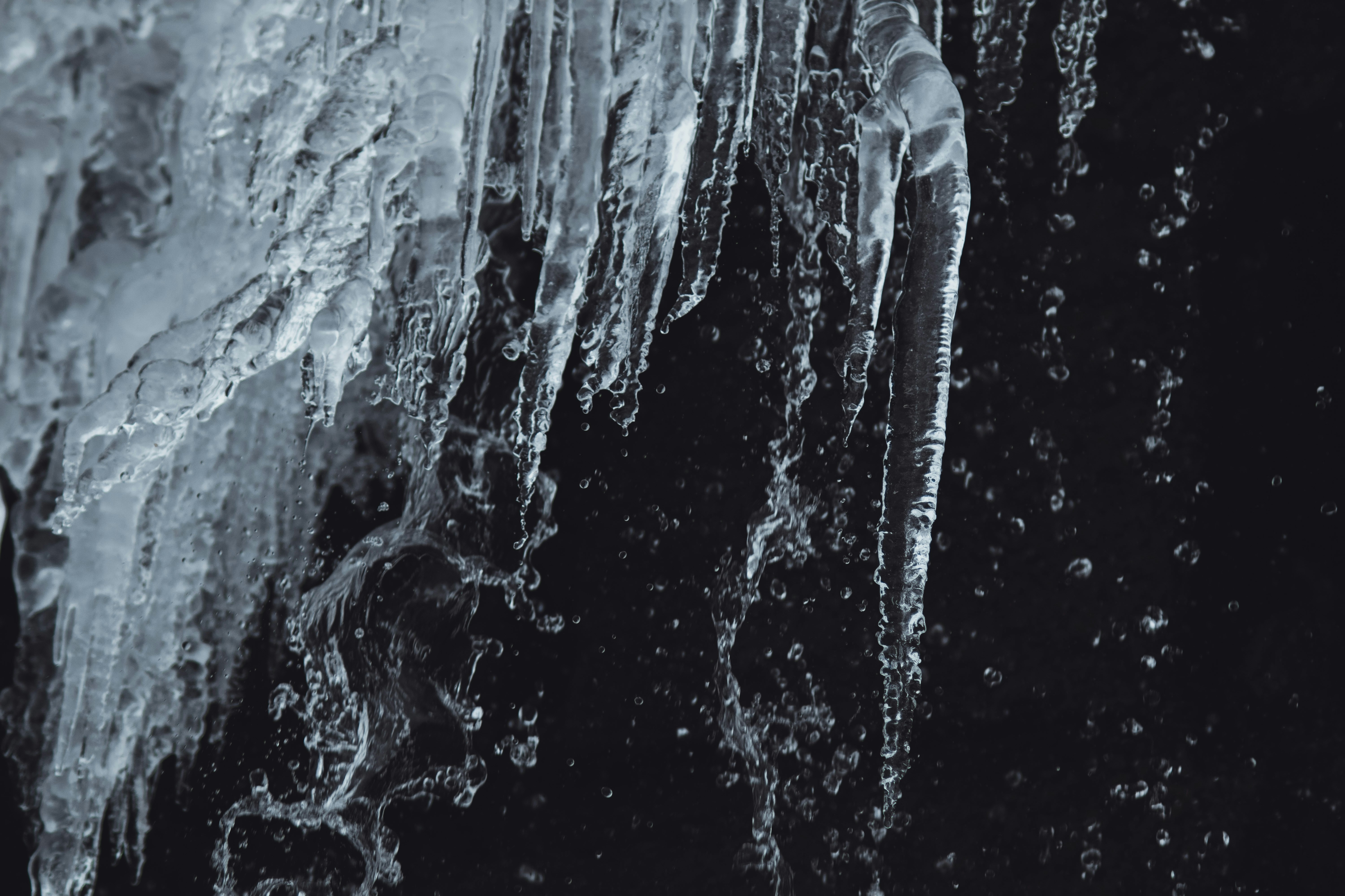 a close up of ice hanging from the side of a mountain