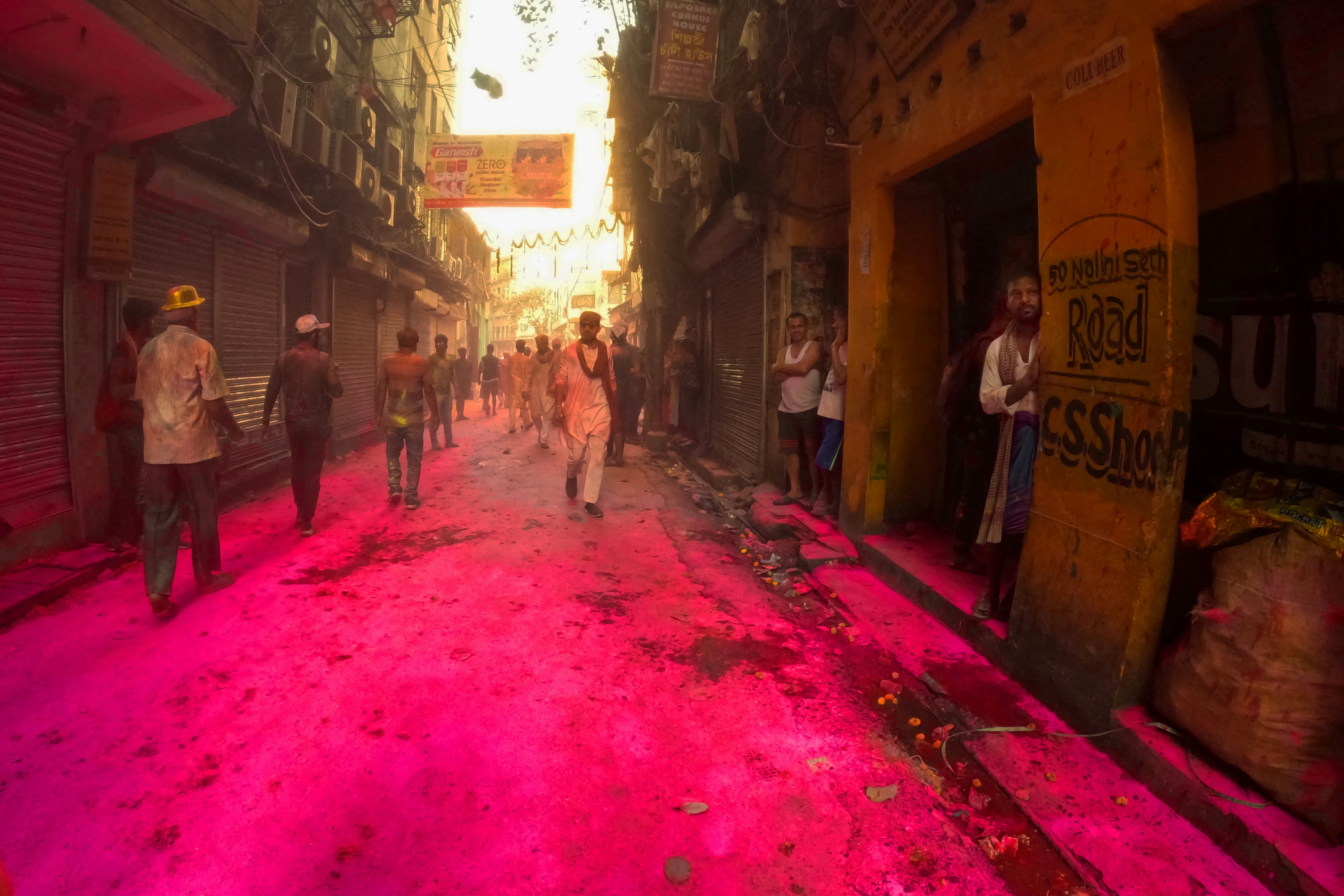 A group of people walking down a street next to tall buildings photo ...