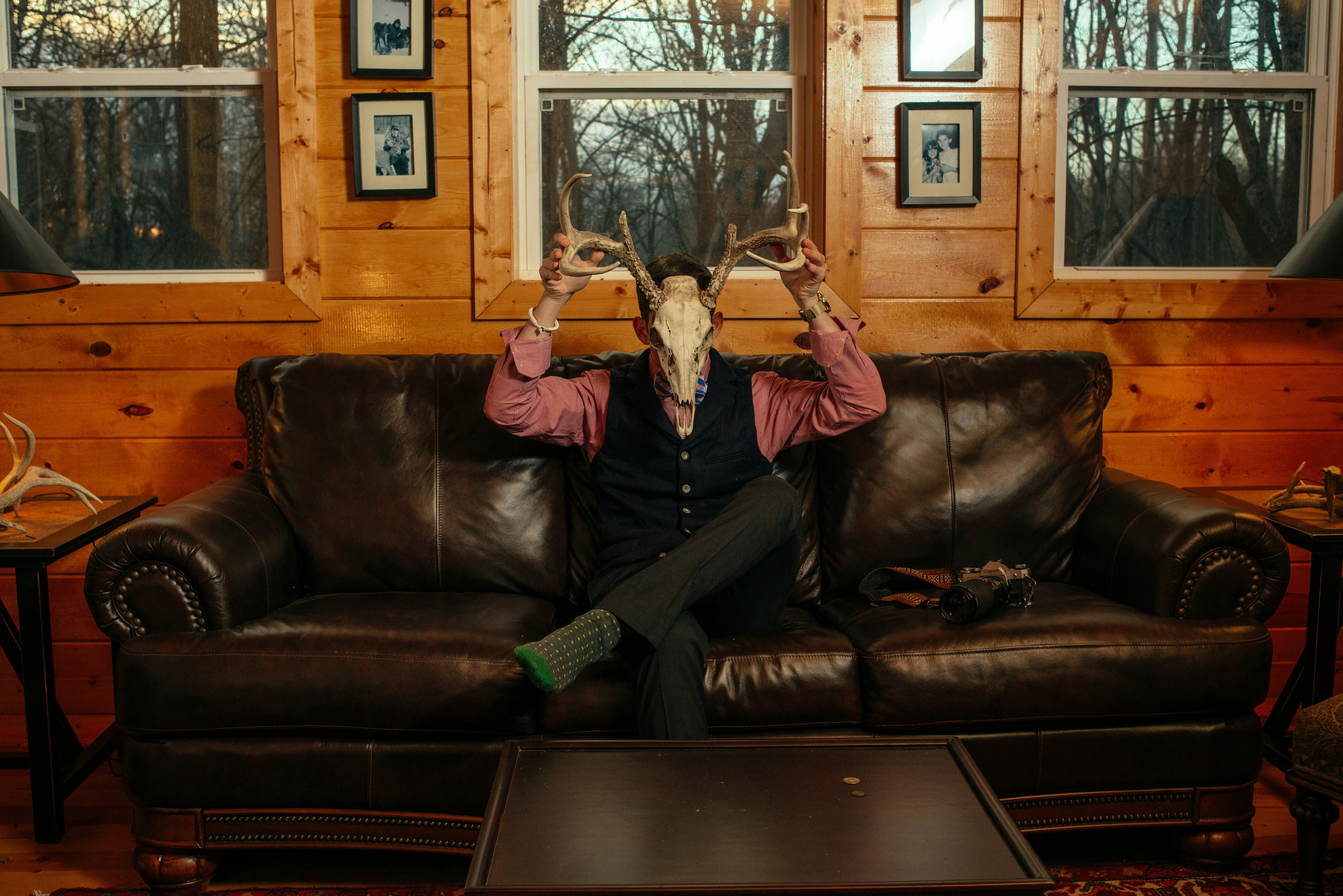The Deer Skull Host in a Pine-Cabin Living Room