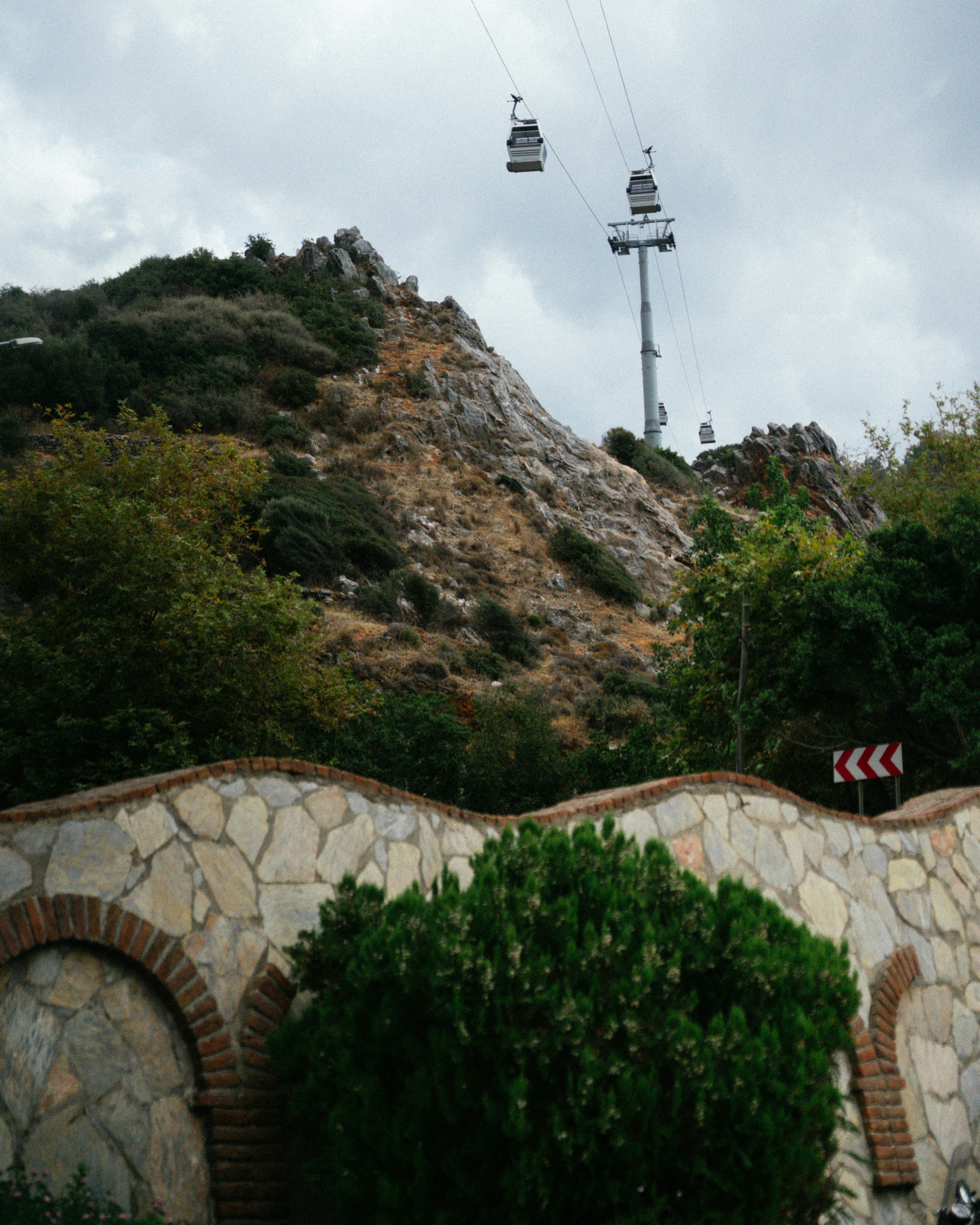 Gondolas Across a Rugged Terrace: A Quiet Ascent Above the Stone Wall