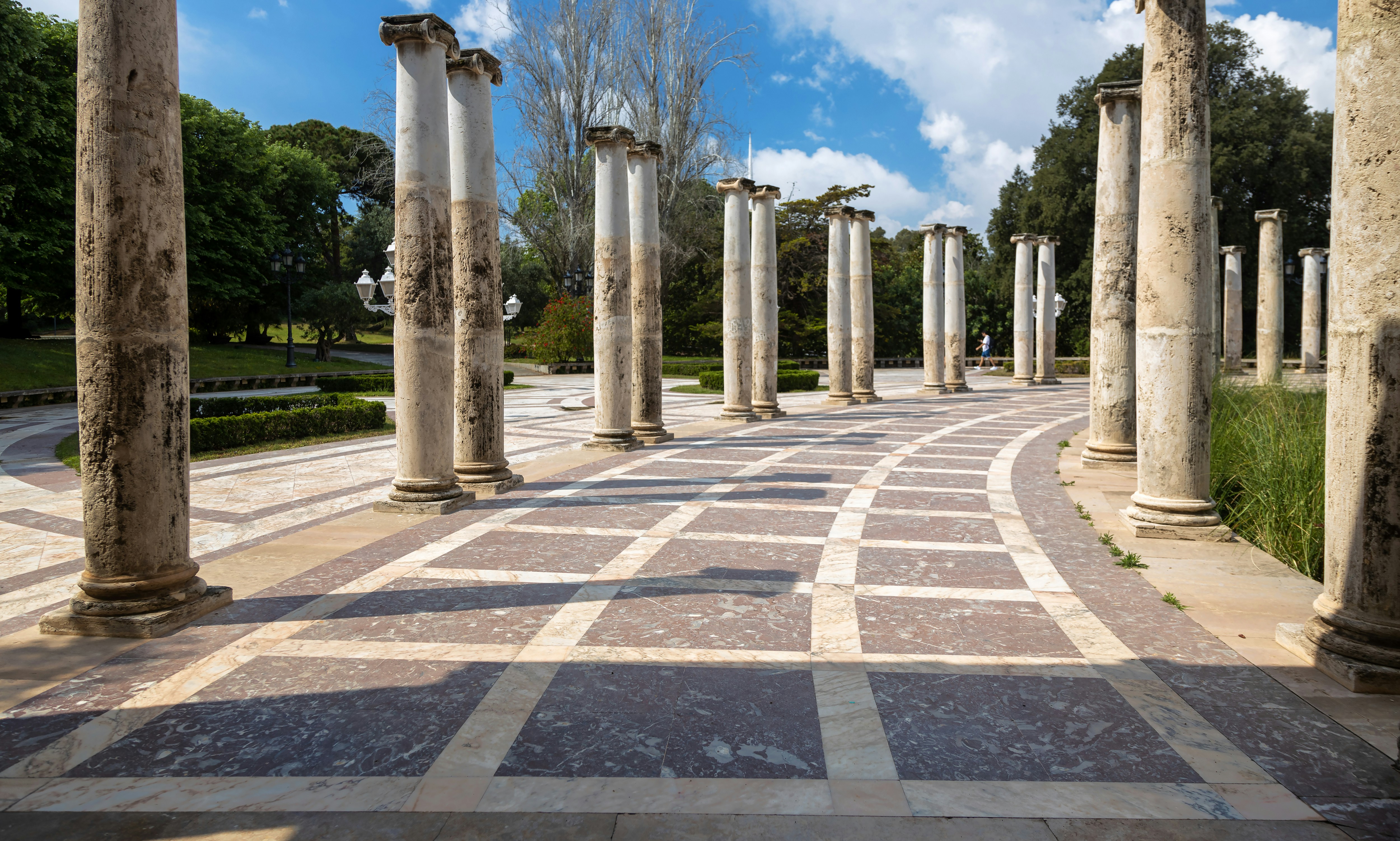 A walkway lined with stone pillars and pillars photo – Free Montjuïc ...
