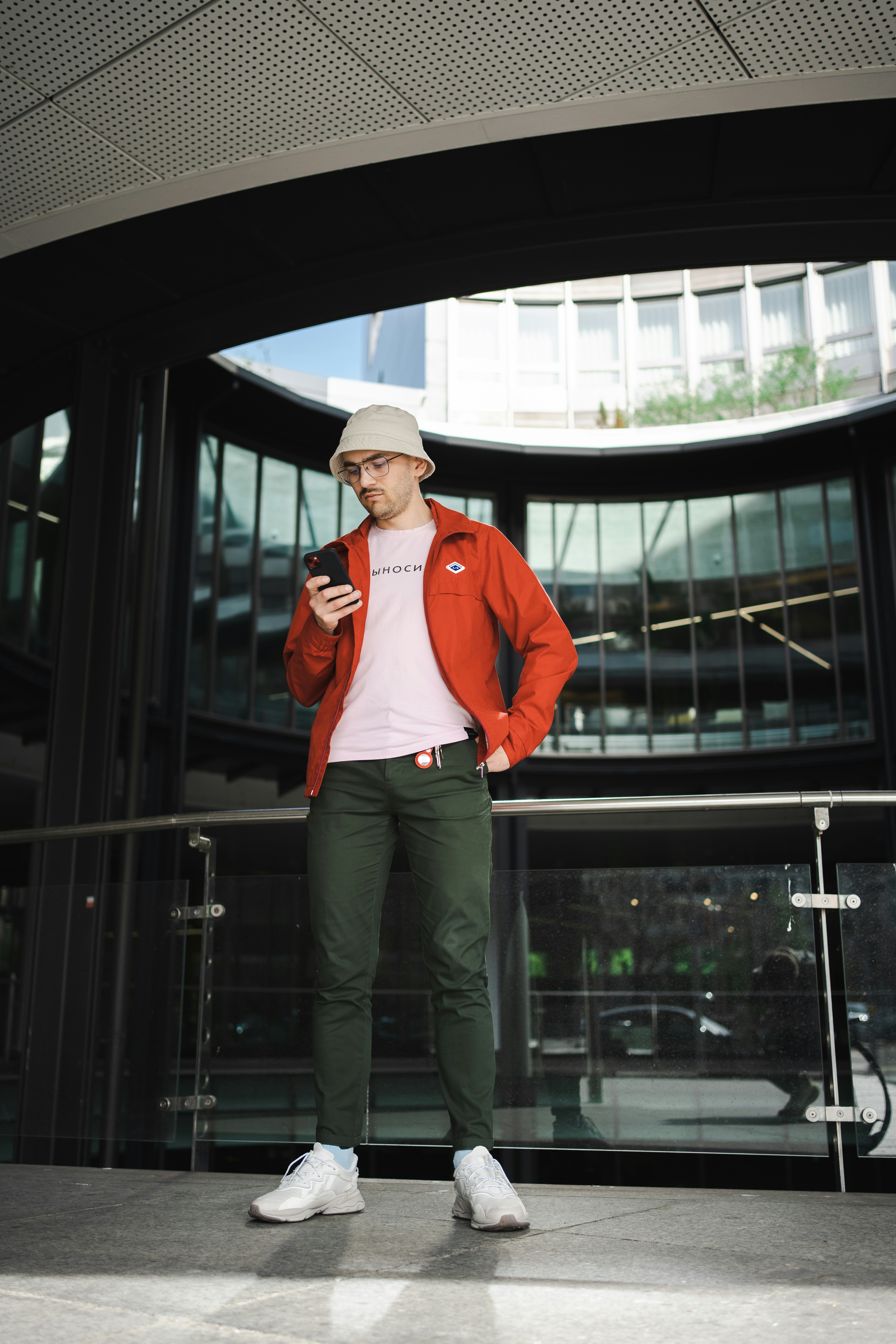 Red-Jacket Portrait in a Curved Glass Atrium