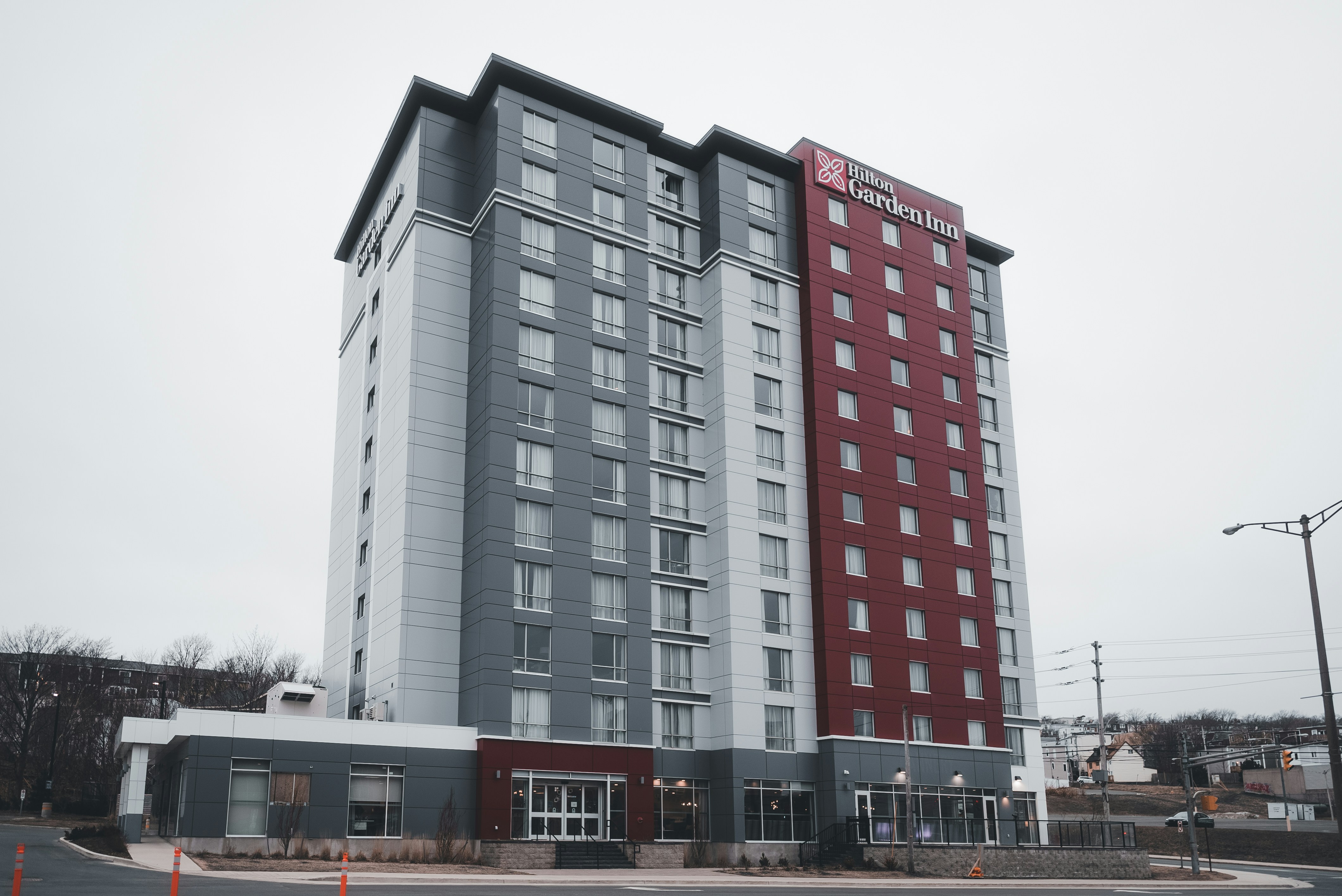 A large red and gray building with a red and white sign photo – Free ...