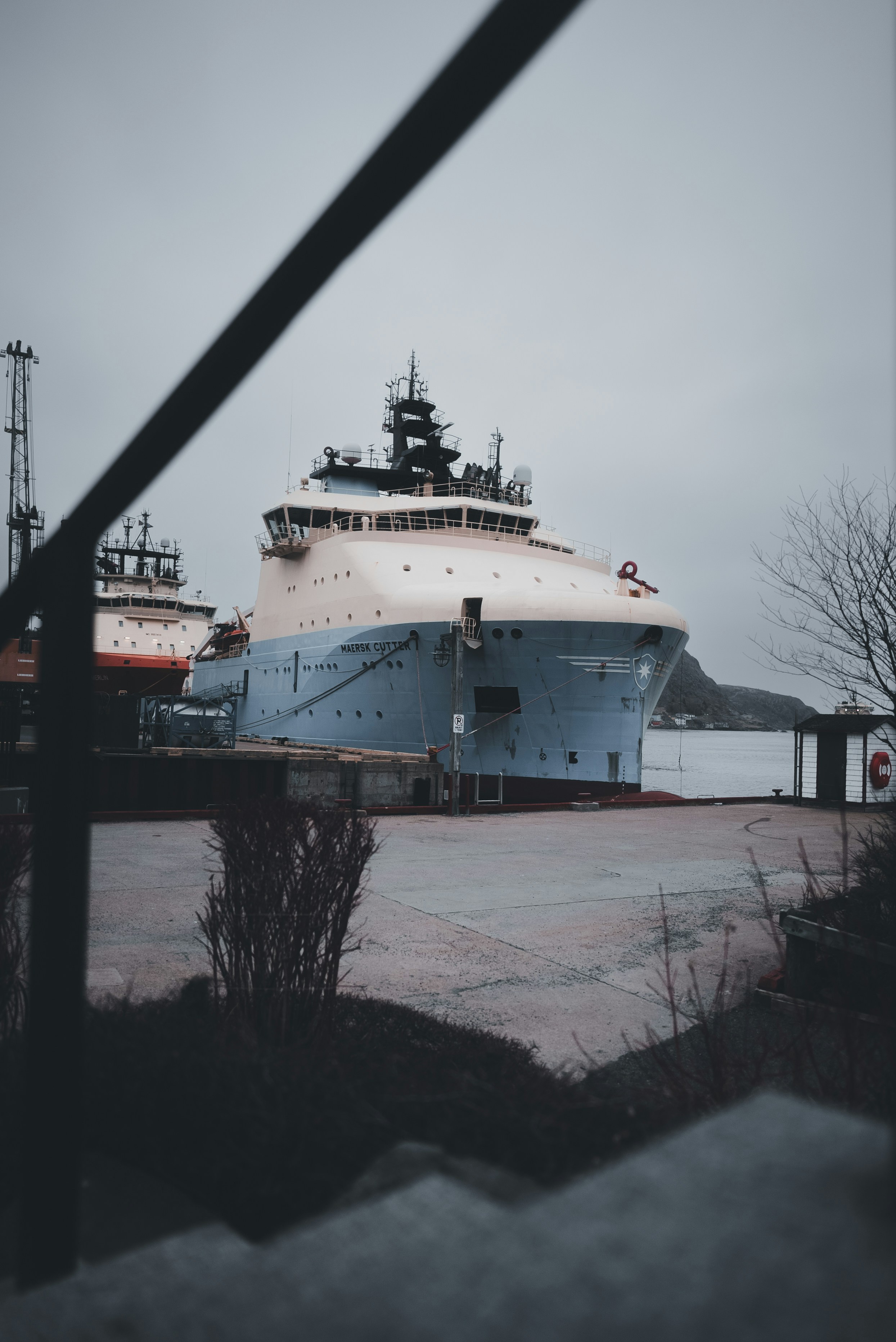Harbor Giant: a blue-hulled cruiser framed by diagonal rails
