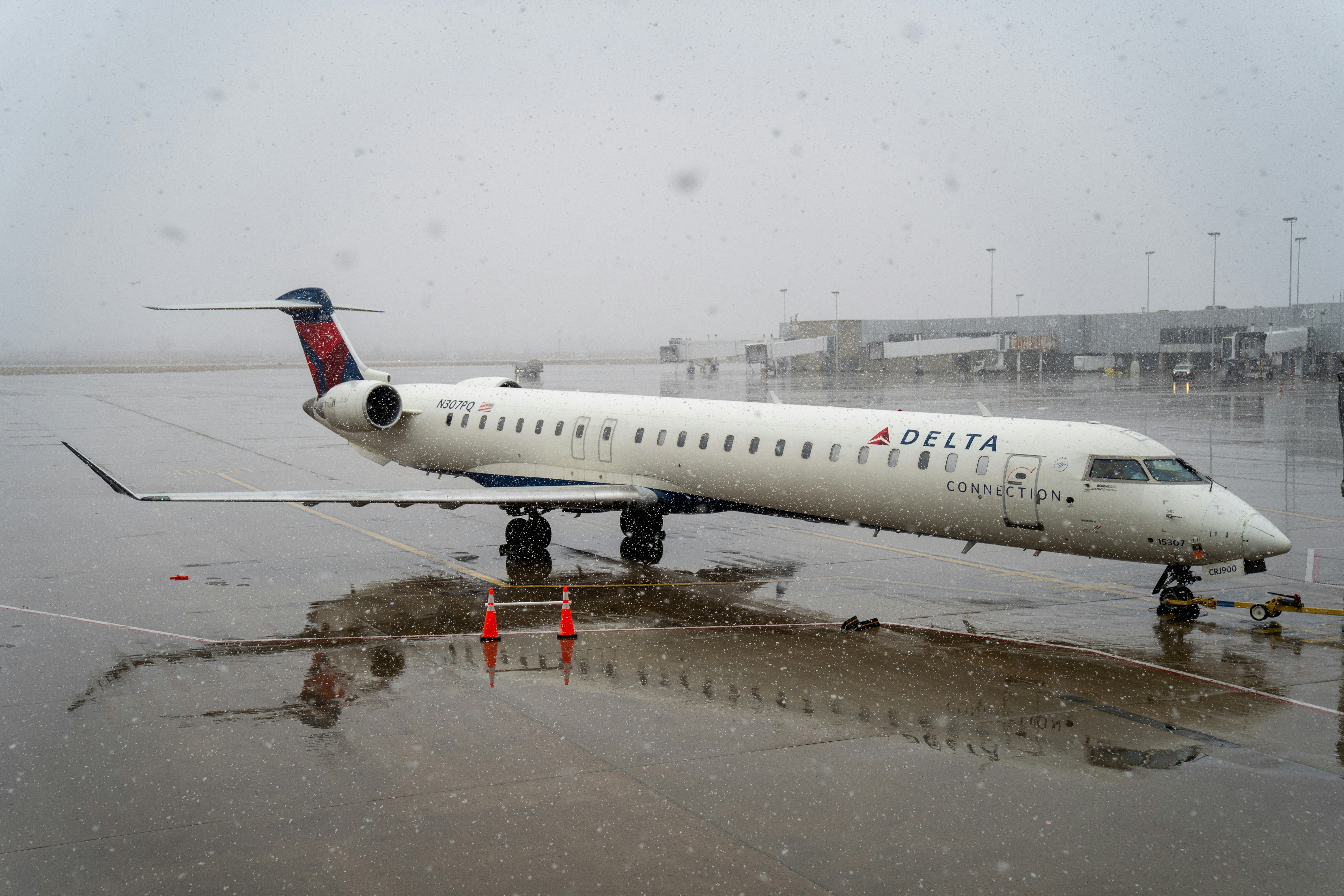 A delta airplane is parked on a wet runway photo – Free Cleveland Image ...