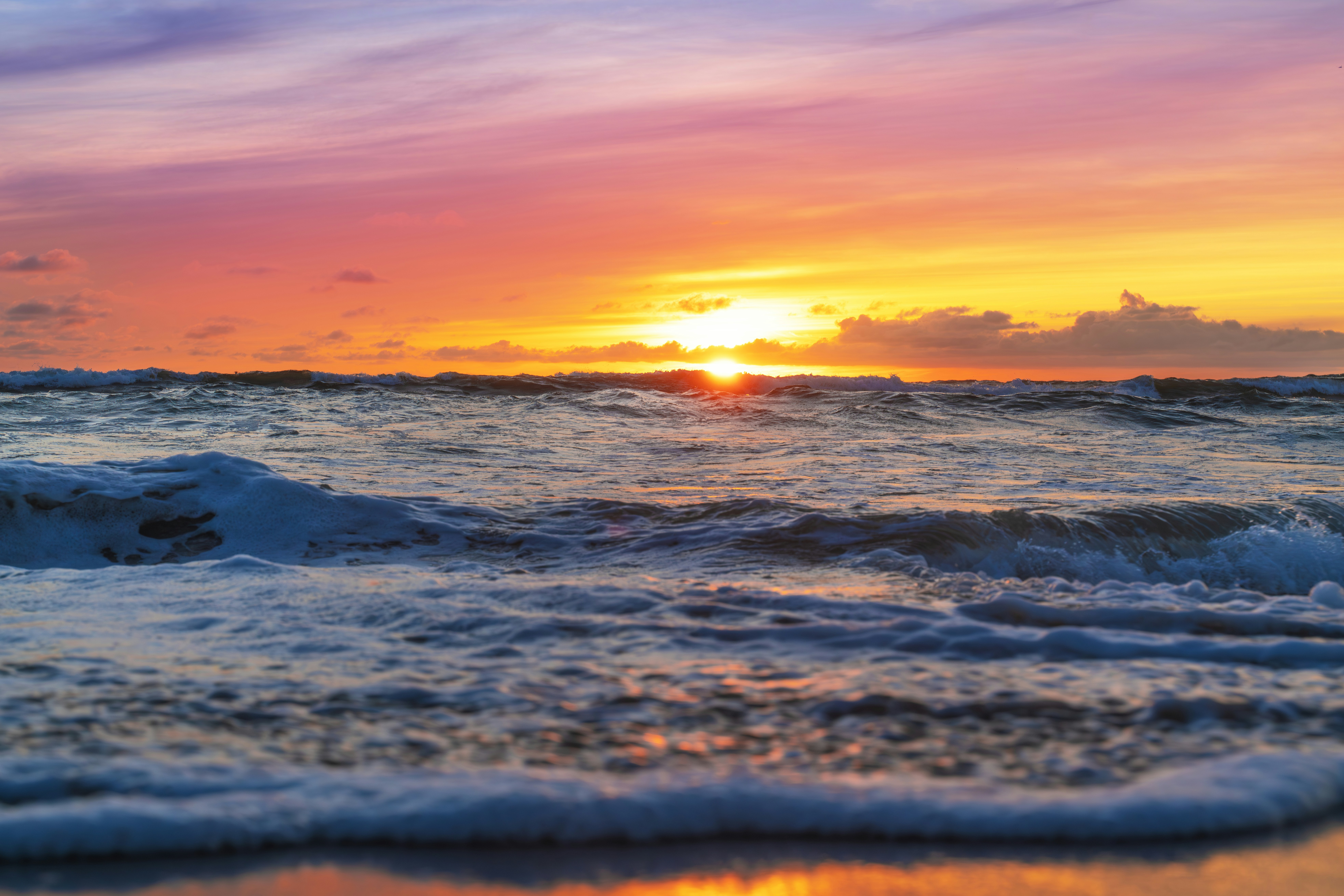 Sunset casting vivid hues over ocean waves at a beach in Los Angeles.