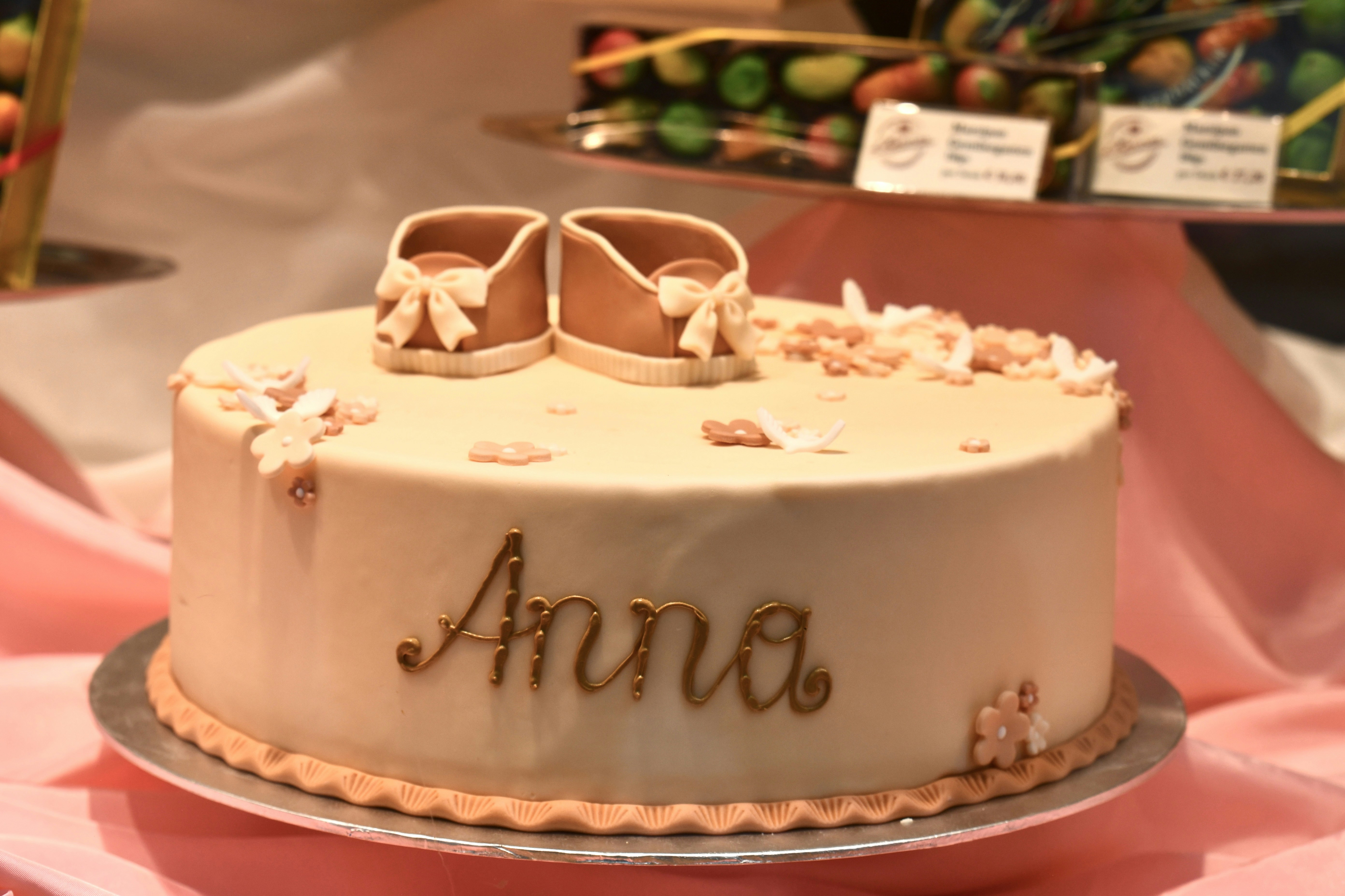 A Sweet Moment: Baby Shoes Adorn a Delicate Birthday Cake