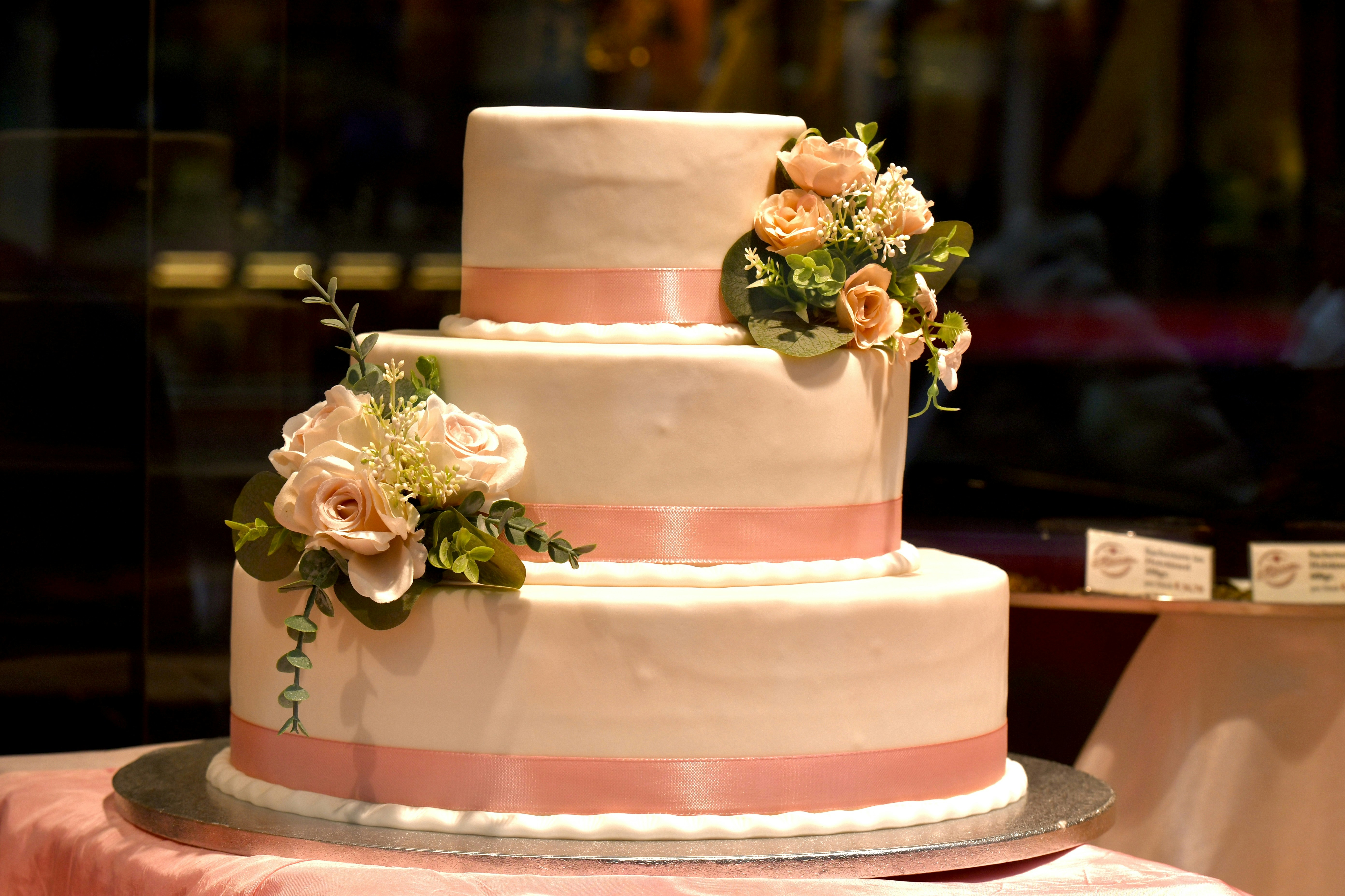A three tiered wedding cake with flowers on top photo – Free Cake Image ...