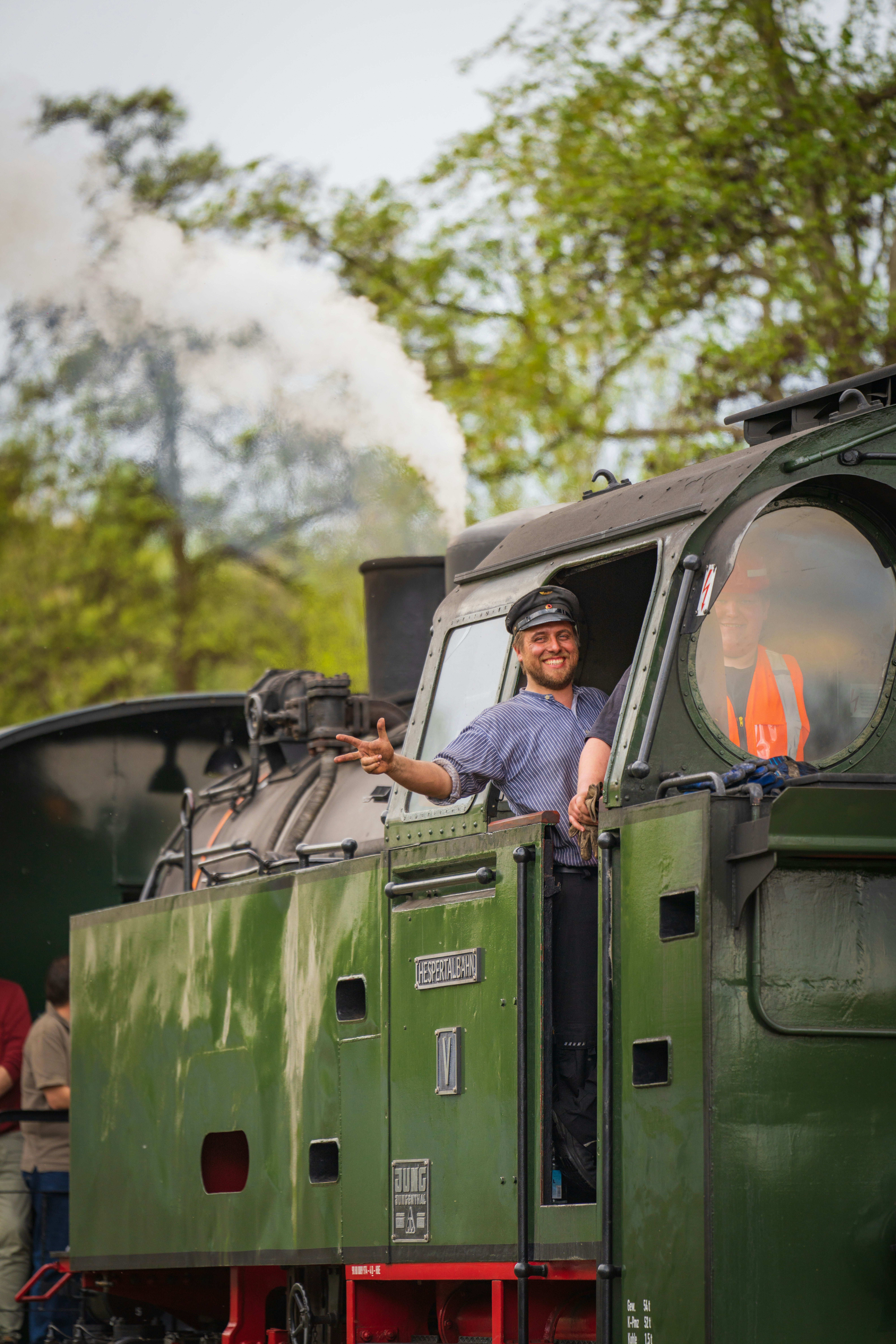 Engineer at the Steam Locomotive: A Friendly Wave from the Cab