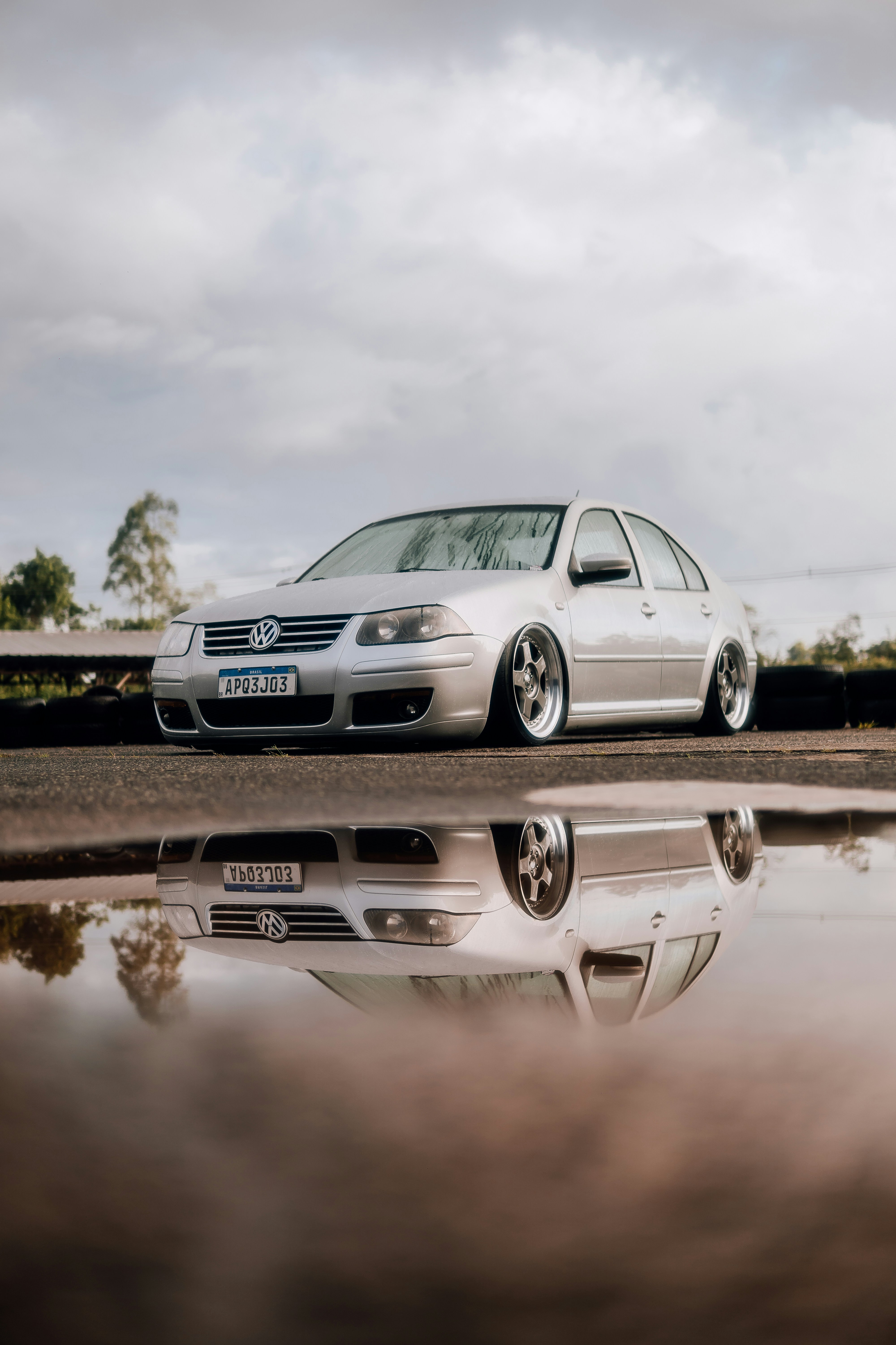 A white car parked next to a puddle of water photo – Free Car Image on ...
