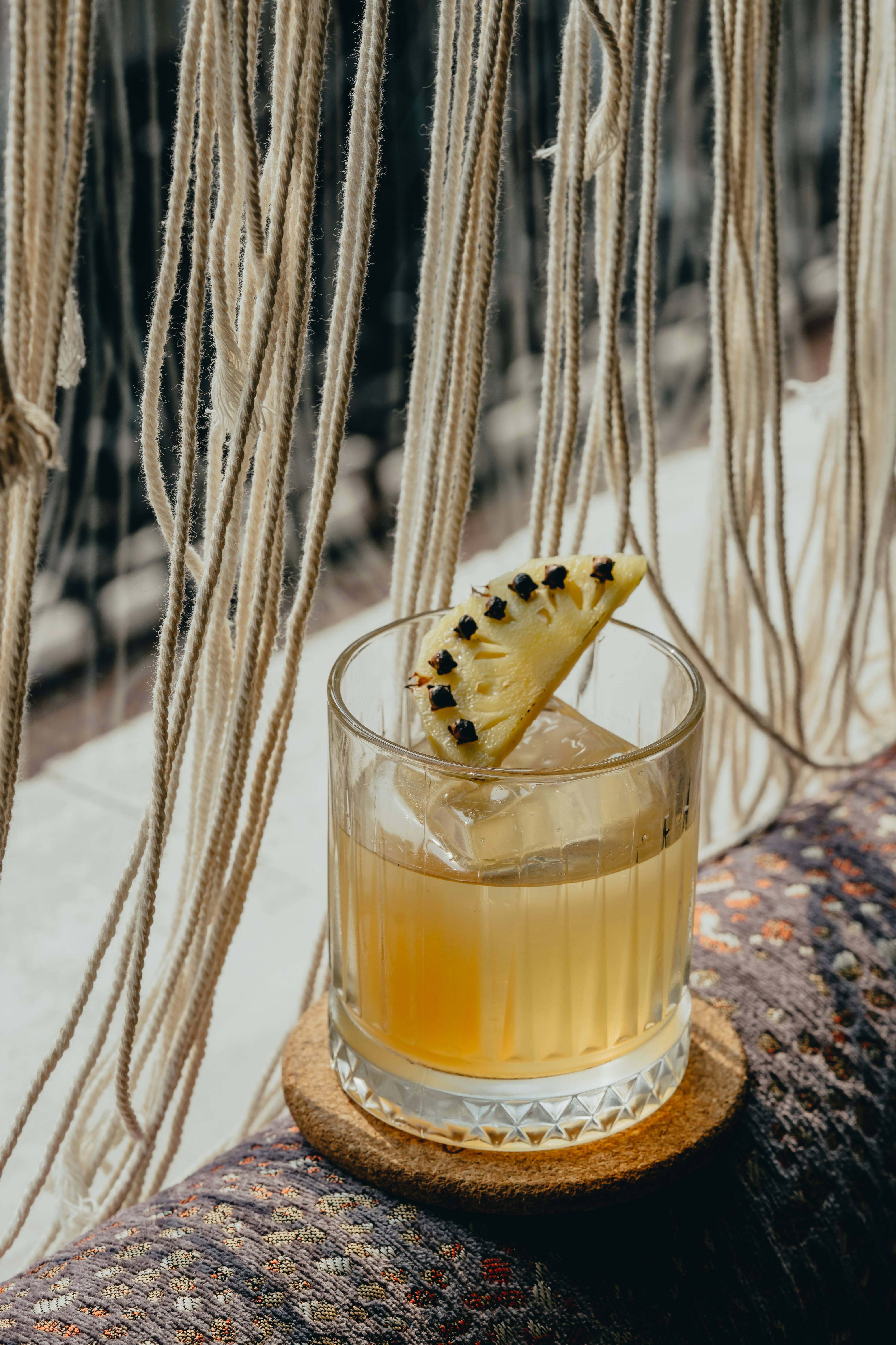 Sunset Sip: A Citrus-tinged Glass Framed by Whimsical Hangs