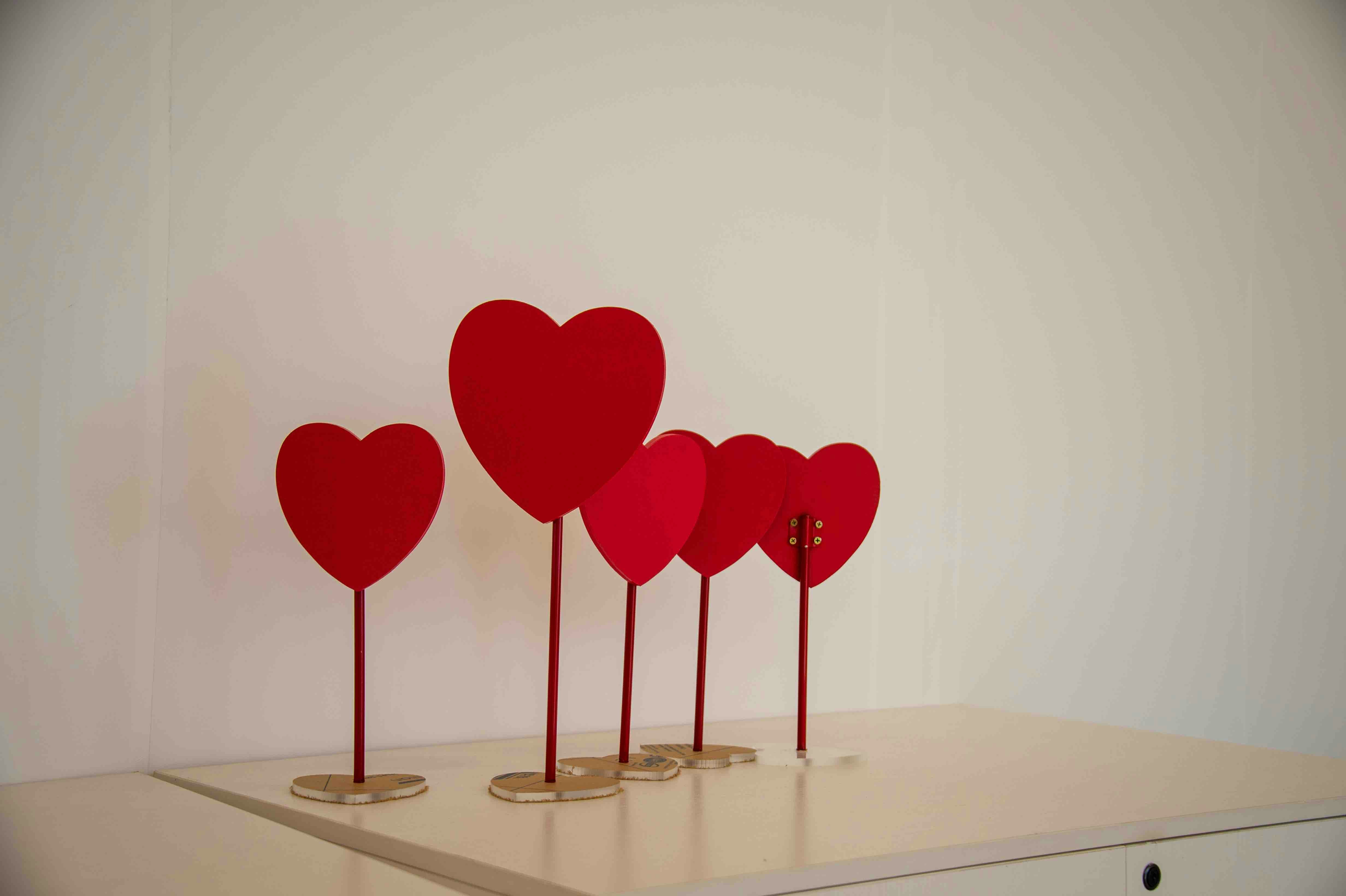 Row of Five Red Heart Sculptures on Slim Stems