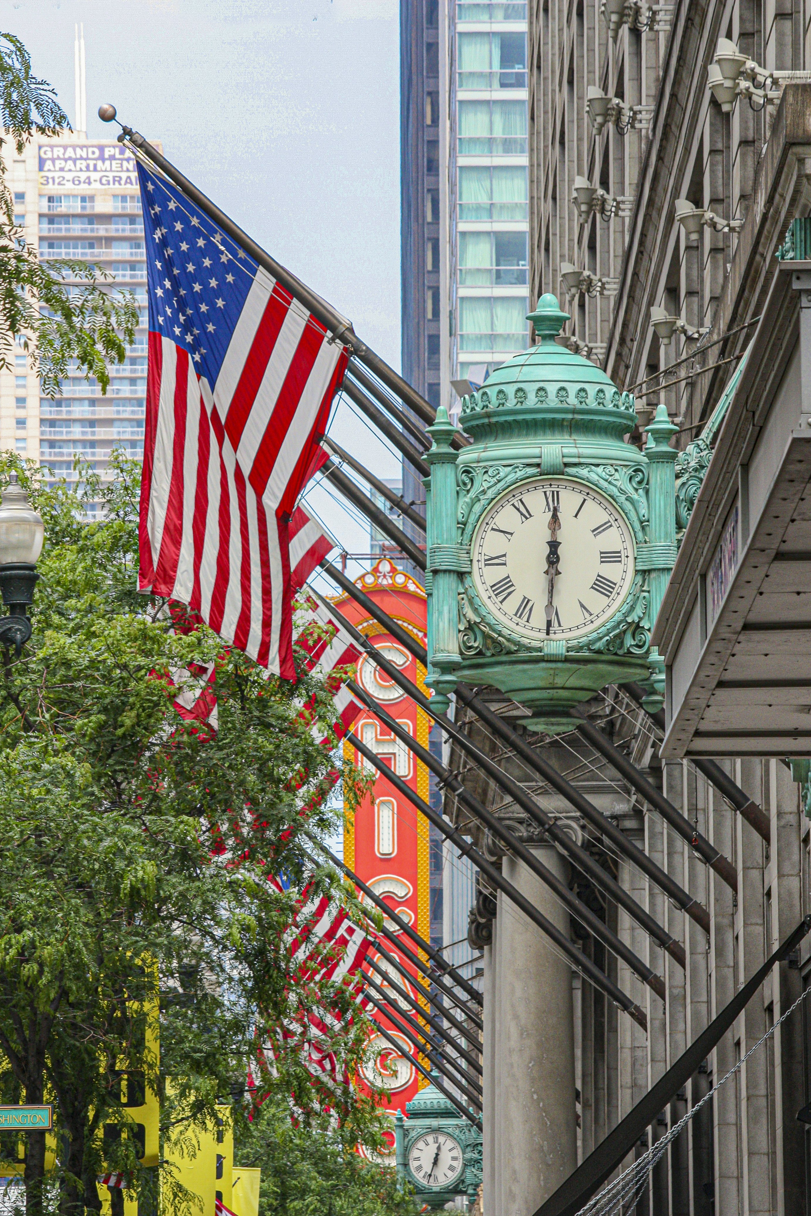 A clock on the side of a building with american flags photo – Free ...