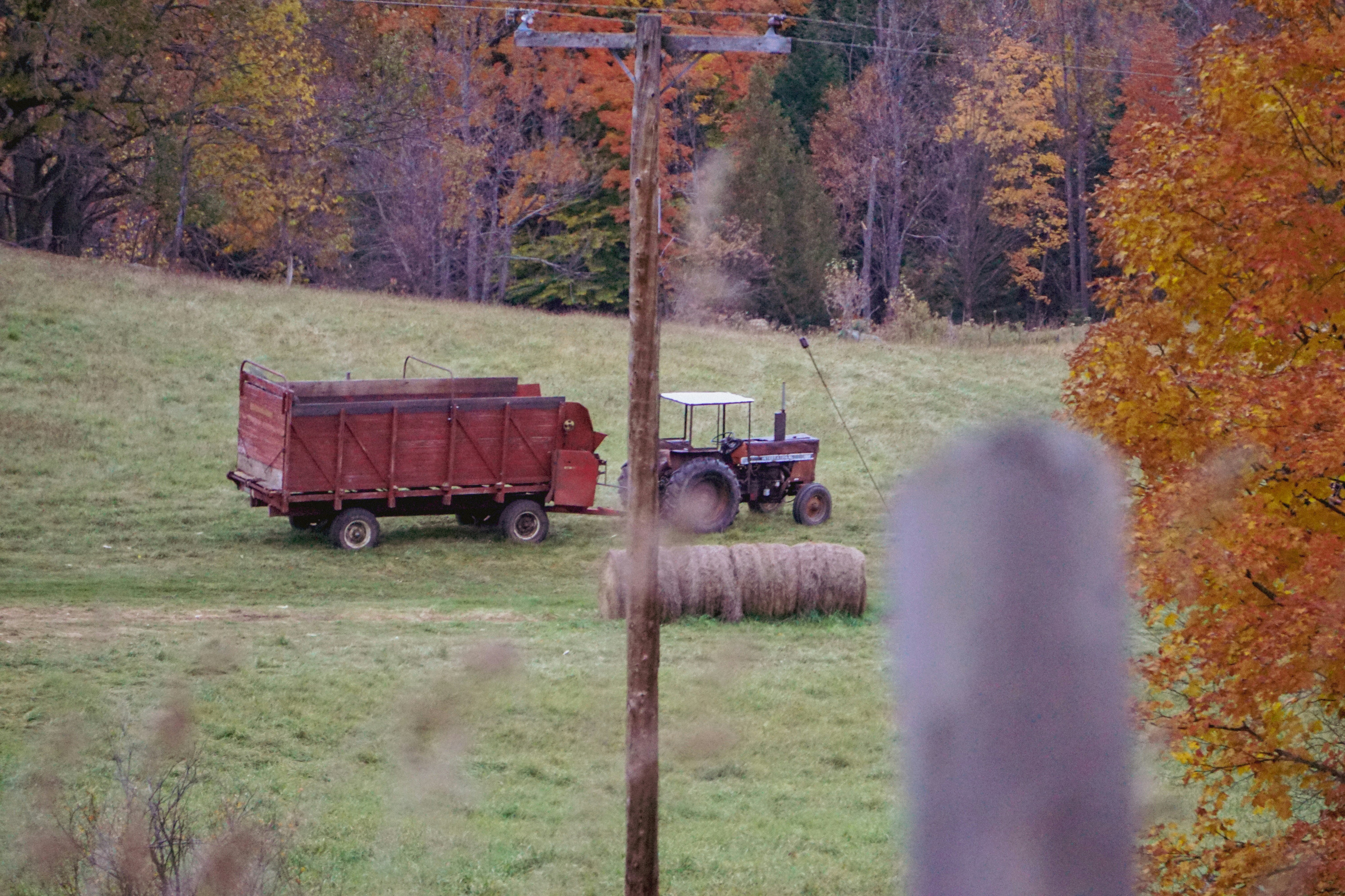 Harvested Quiet: Tractor with a Red Wagon in a Golden Autumn Field
